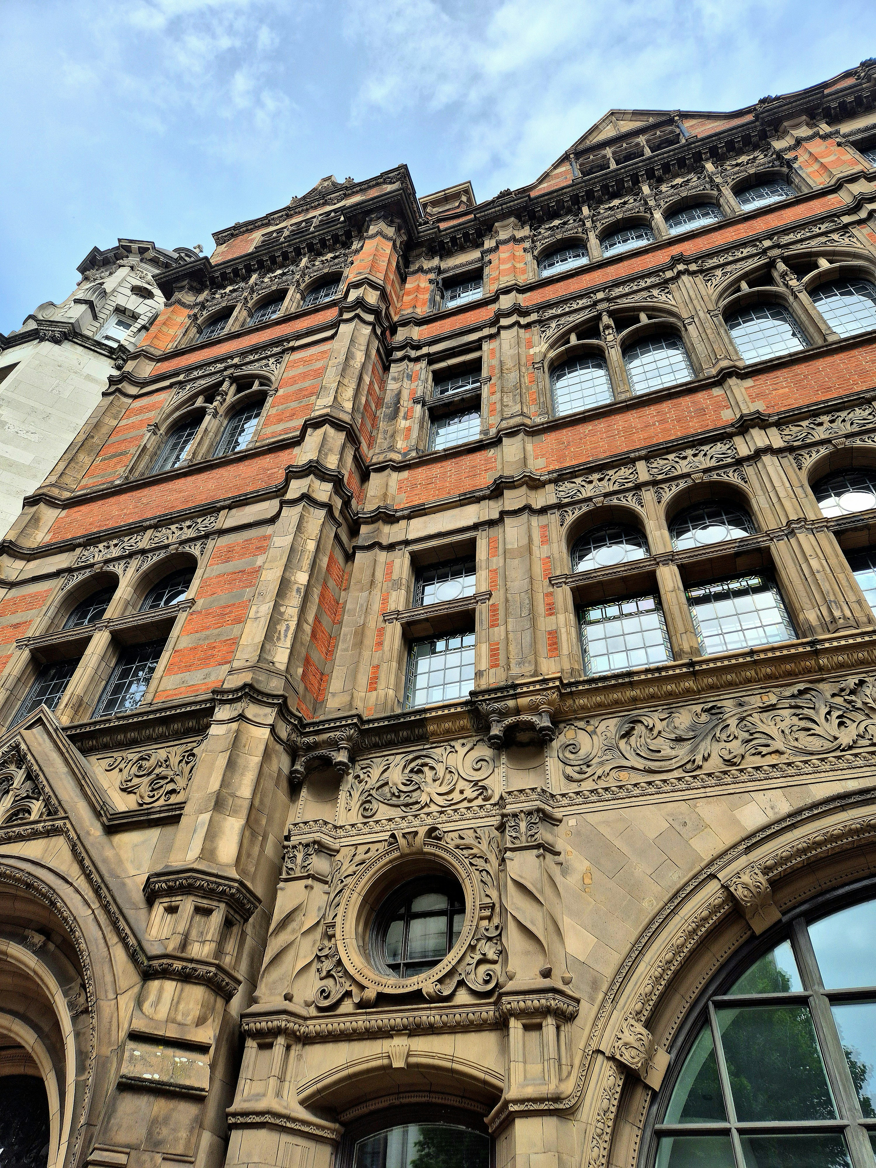 Ornate Facade Rising: A Victorian Brick-and-Stone Elevation Telling Time