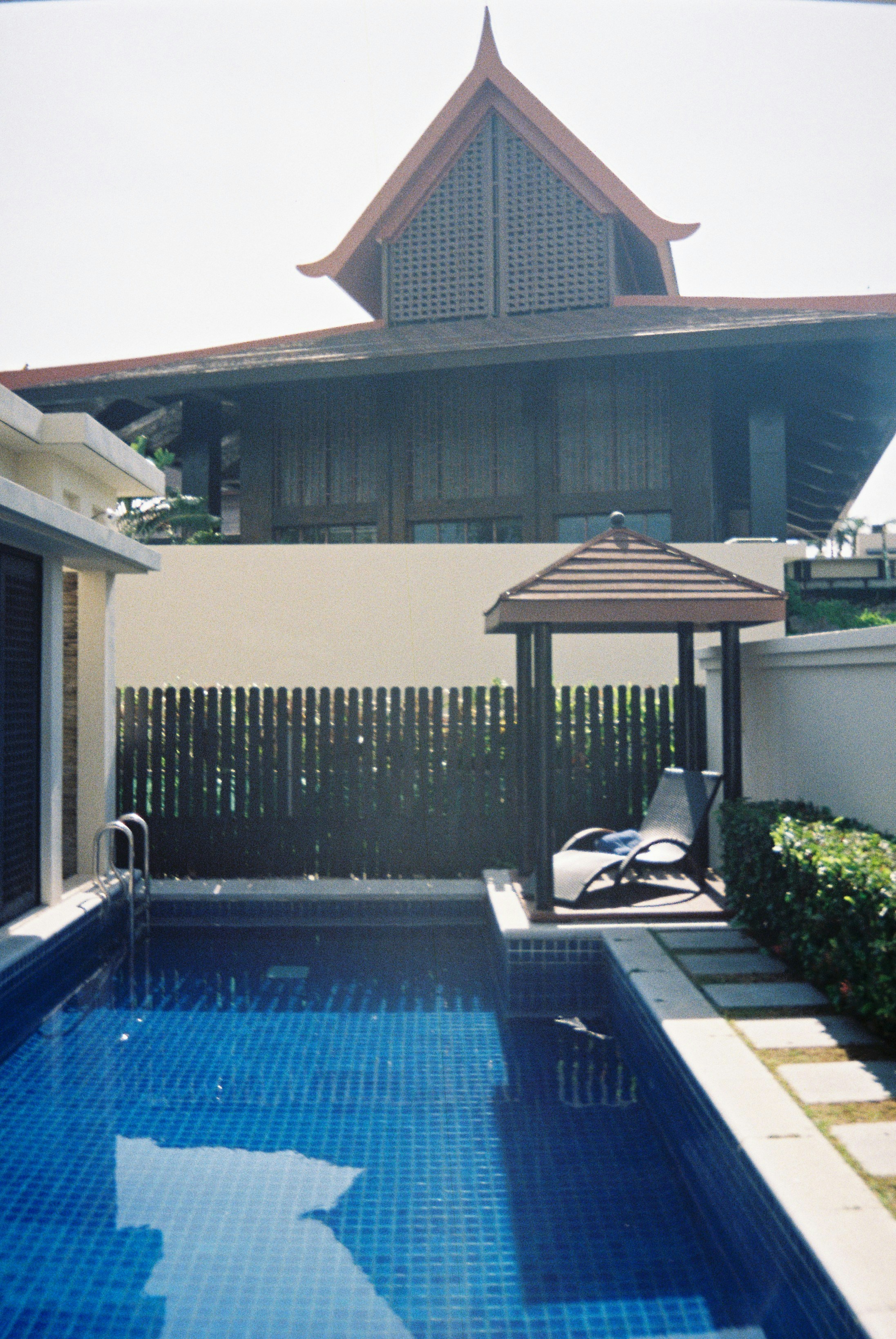A private swimming pool with a gazebo and traditional building.