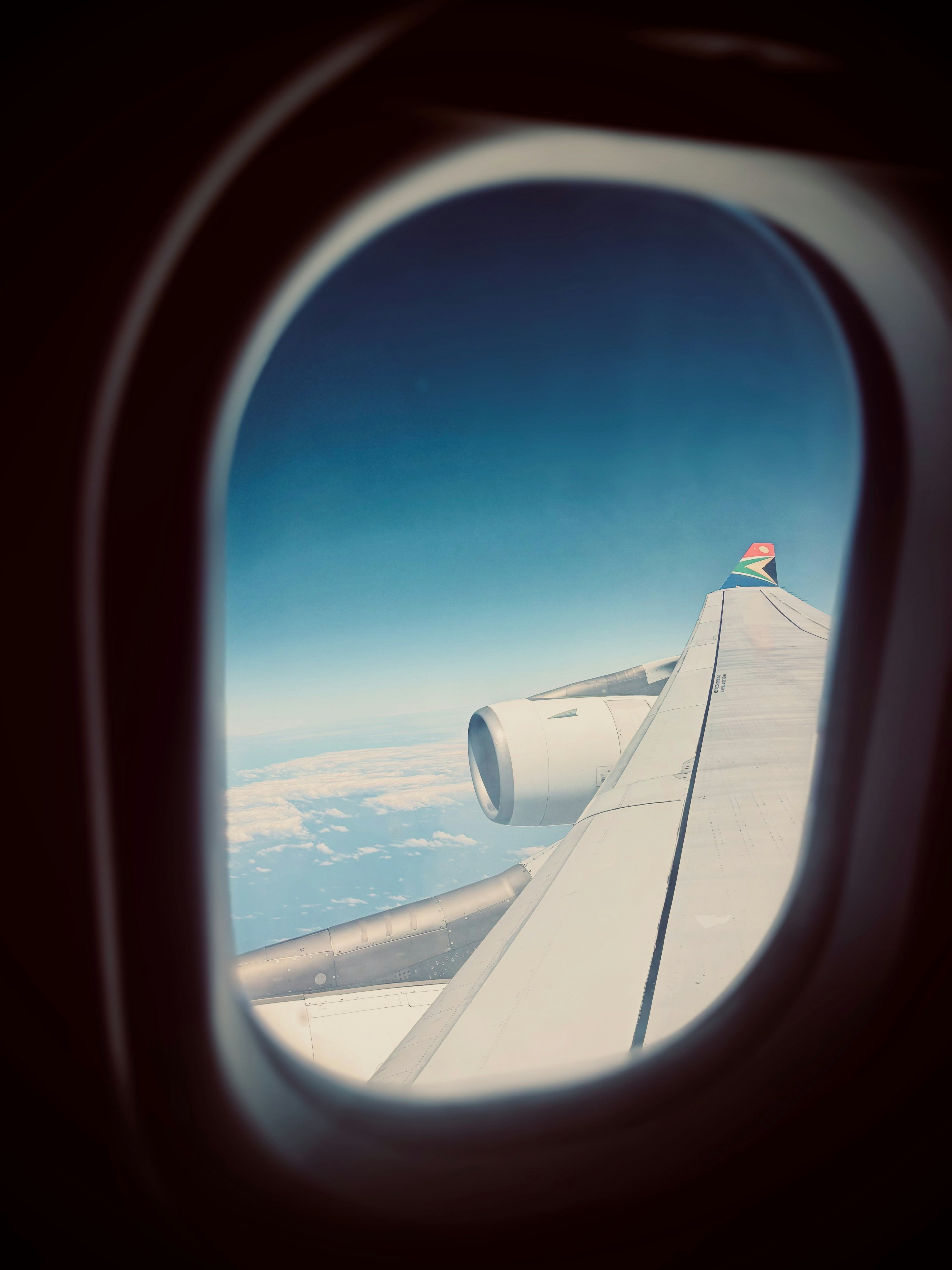 Window Frame and Wing Span: A Skyward Perspective from Economy Class