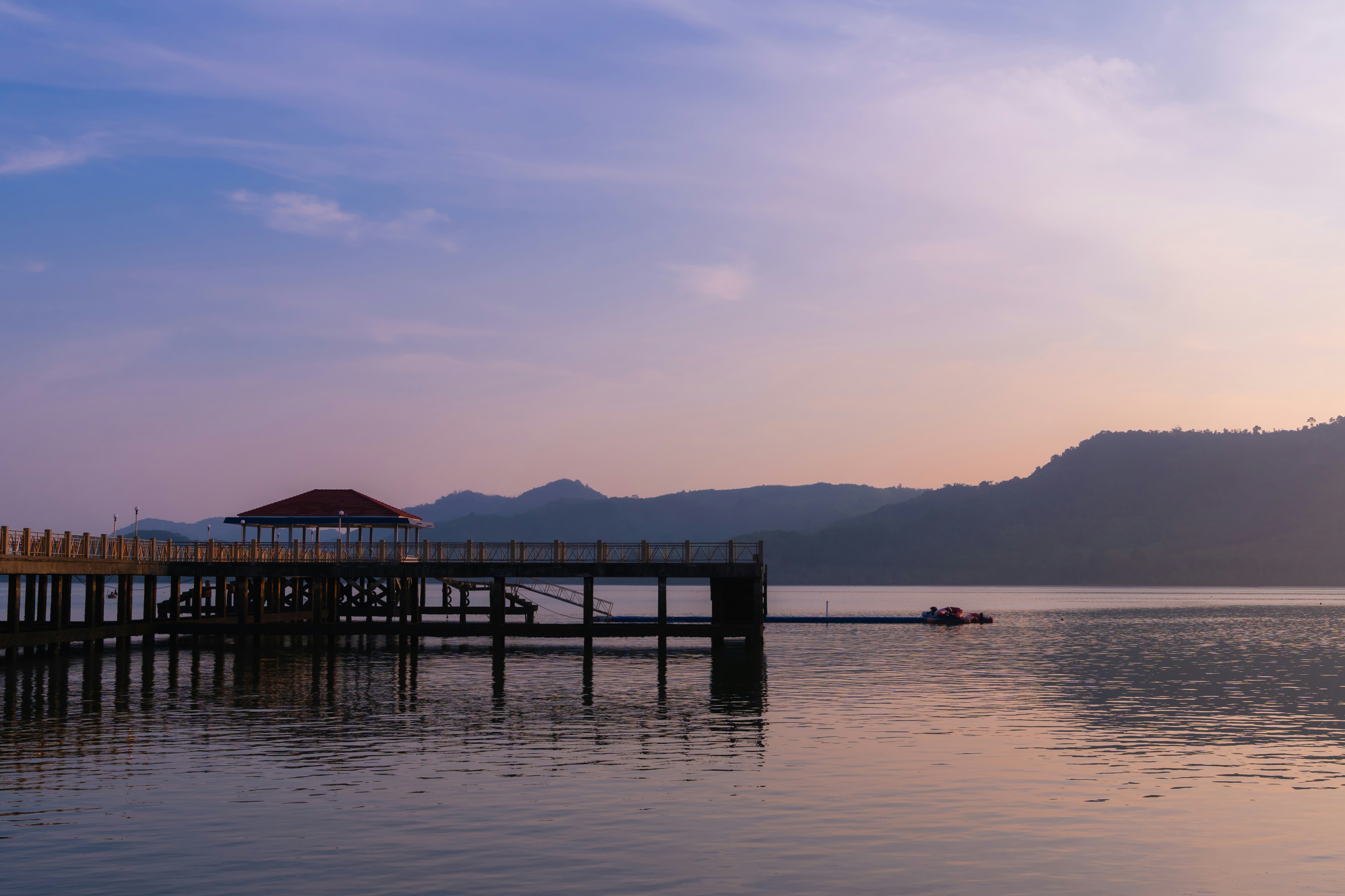 Quiet Pier at Dusk: A Tranquil Lake Scene with a Lantern-Shadowed Boardwalk
