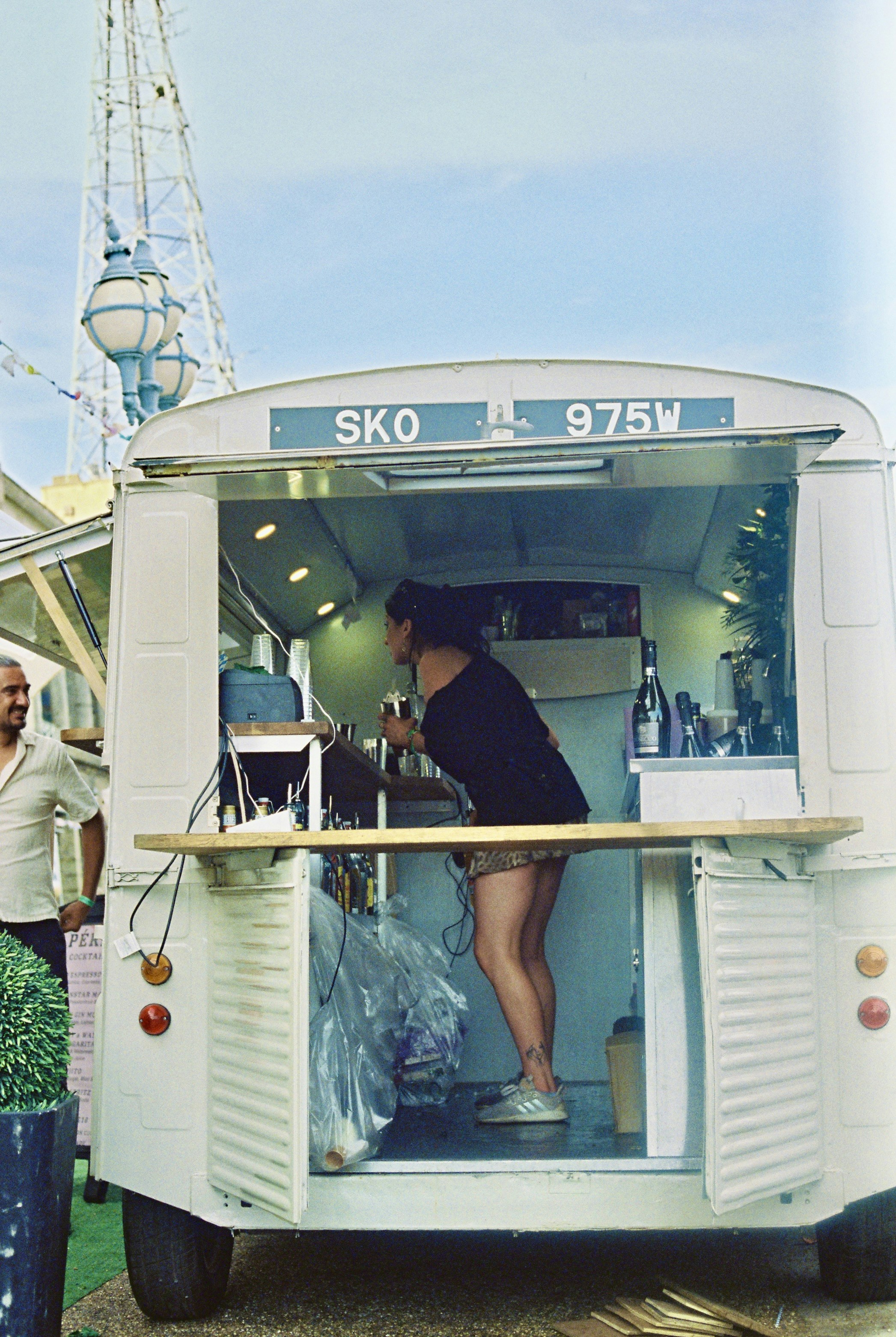 Bar counter in motion: bartender mid-serve inside a retro food truck