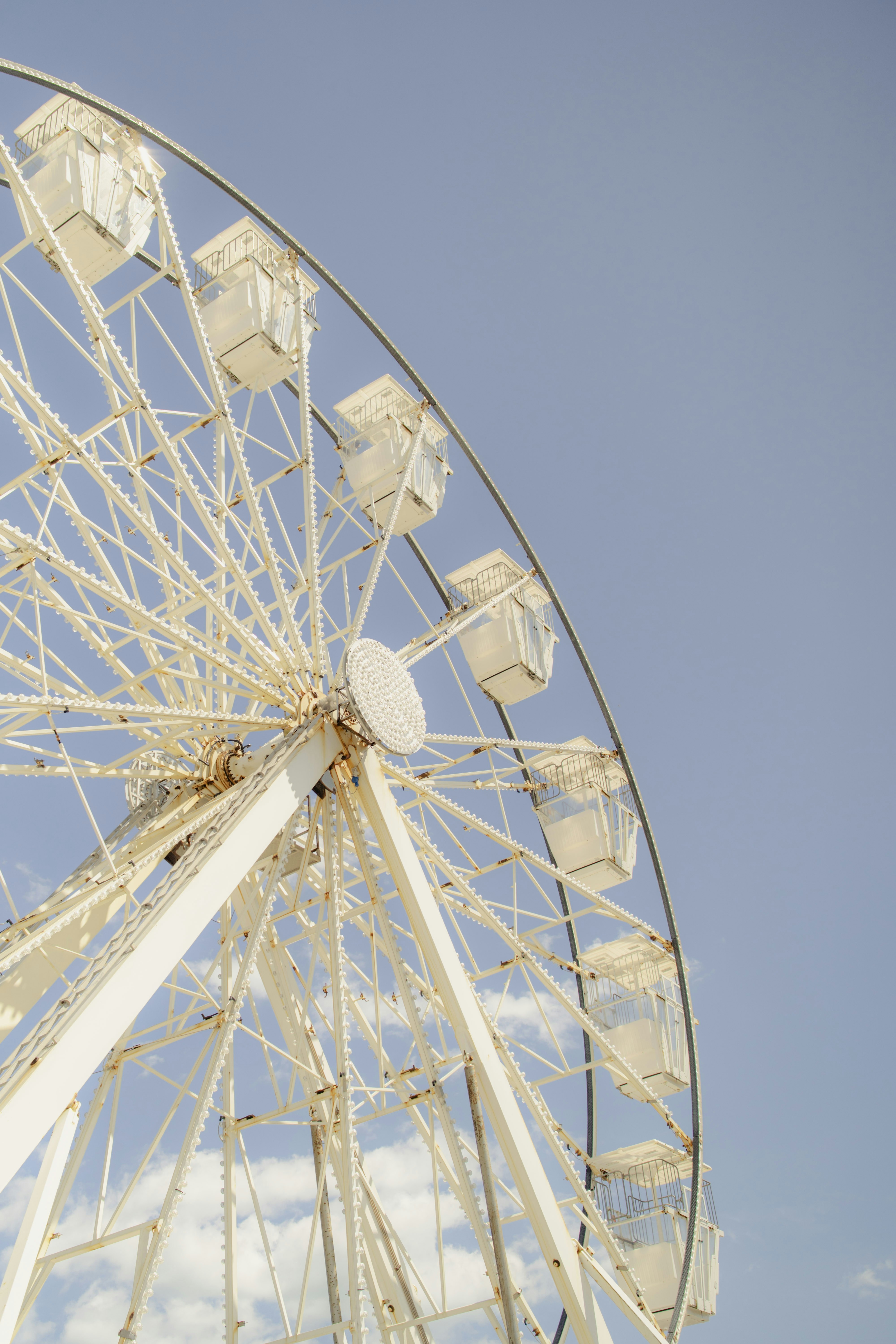 Giant Wheel Skimming the Sky: A Ferris Wheel Against a Clear Blue Canvas
