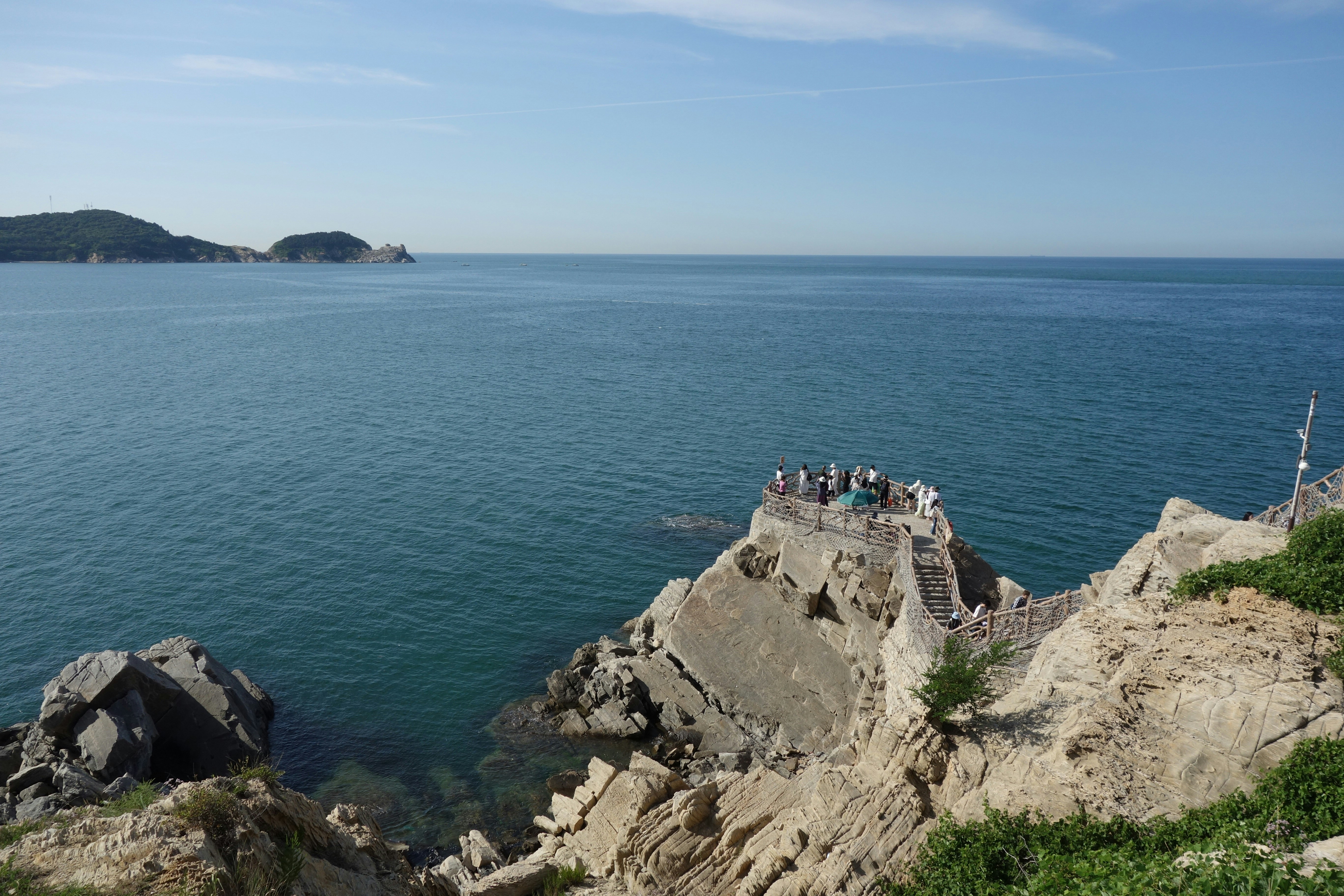 Clifftop Viewpoint: Tourists Gathering at the Edge of the Sea