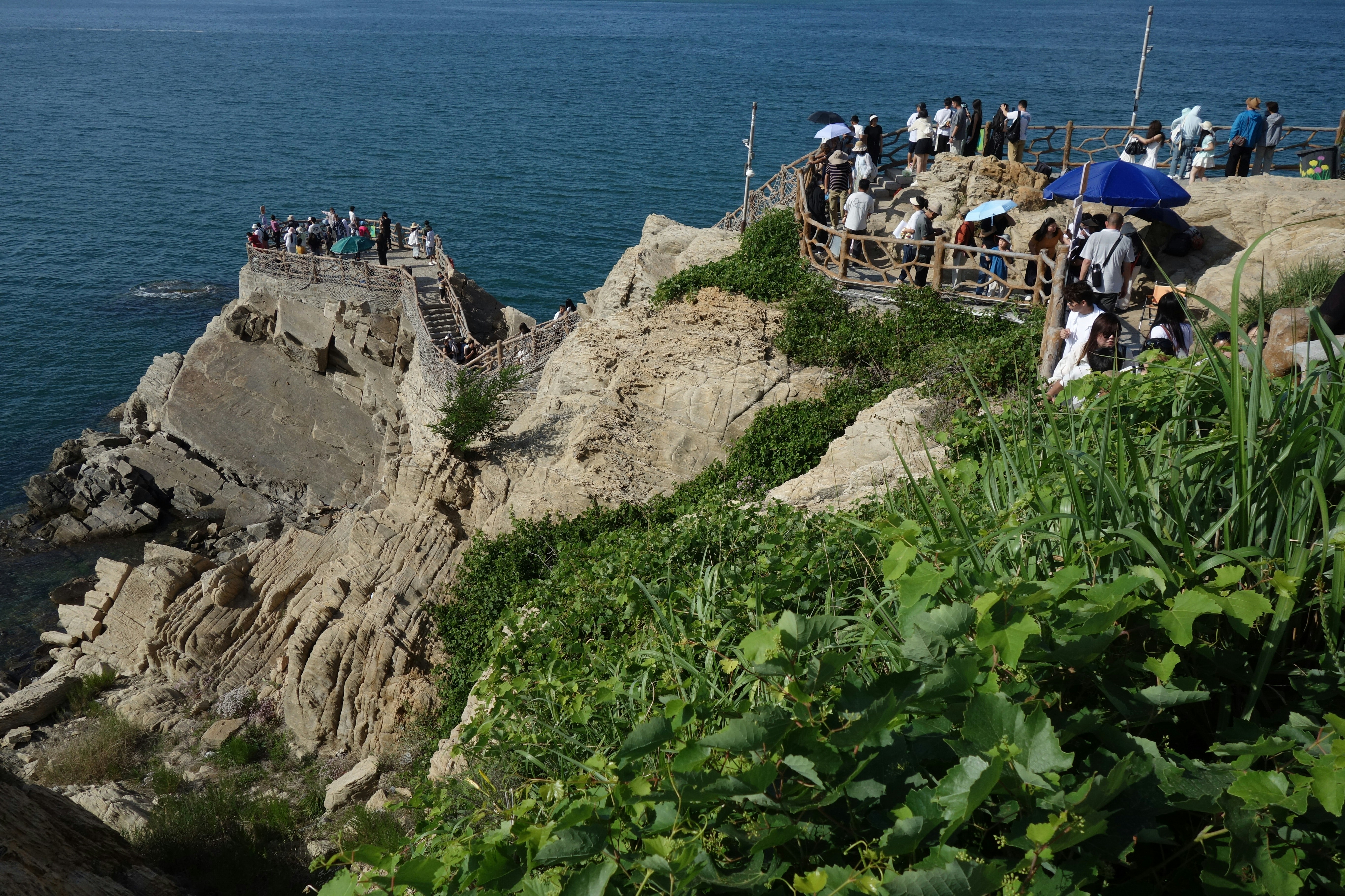 Crowded cliffside viewing platform over the sea