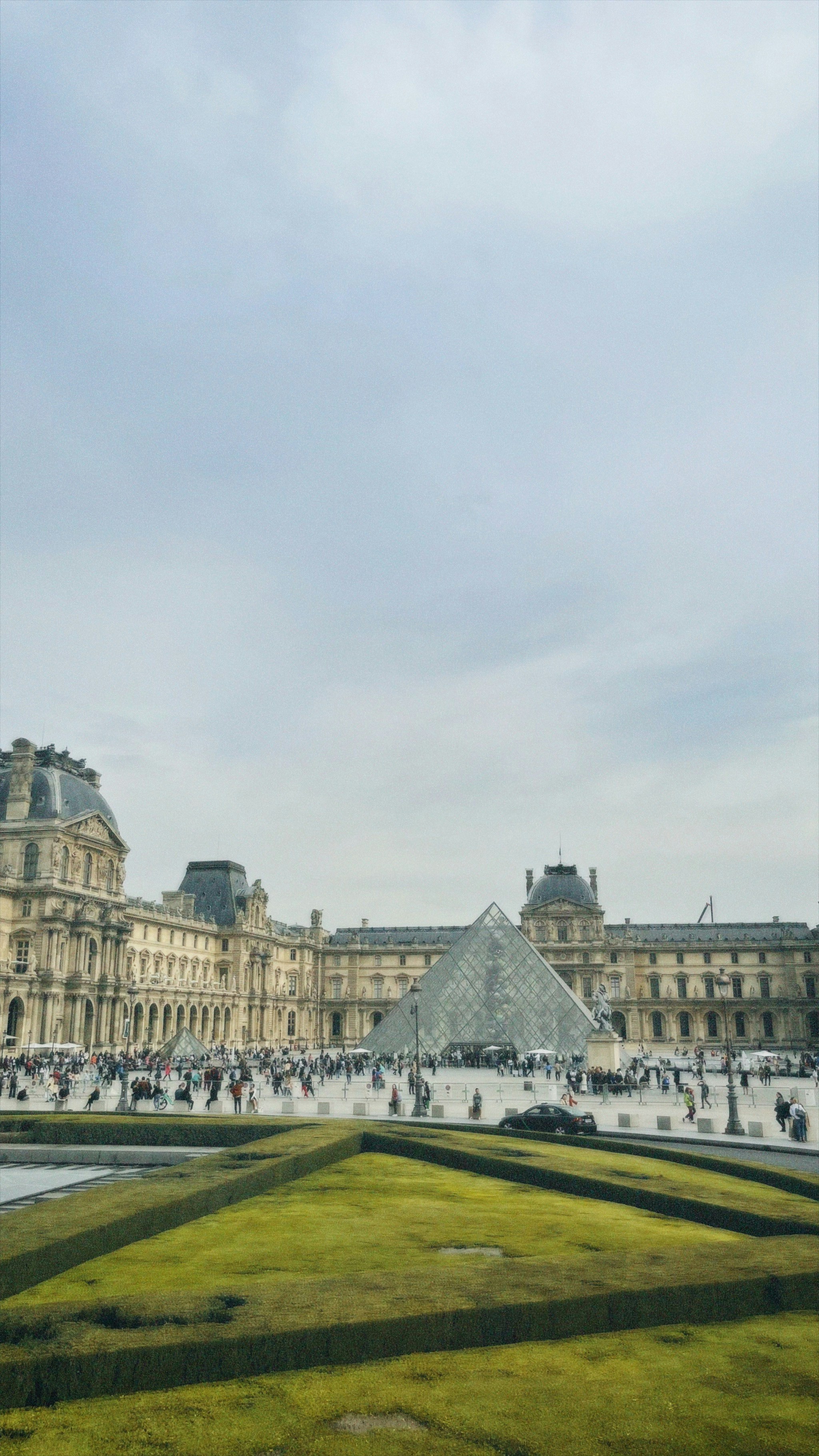 Glass Pyramid Overlooked by Historic Facade