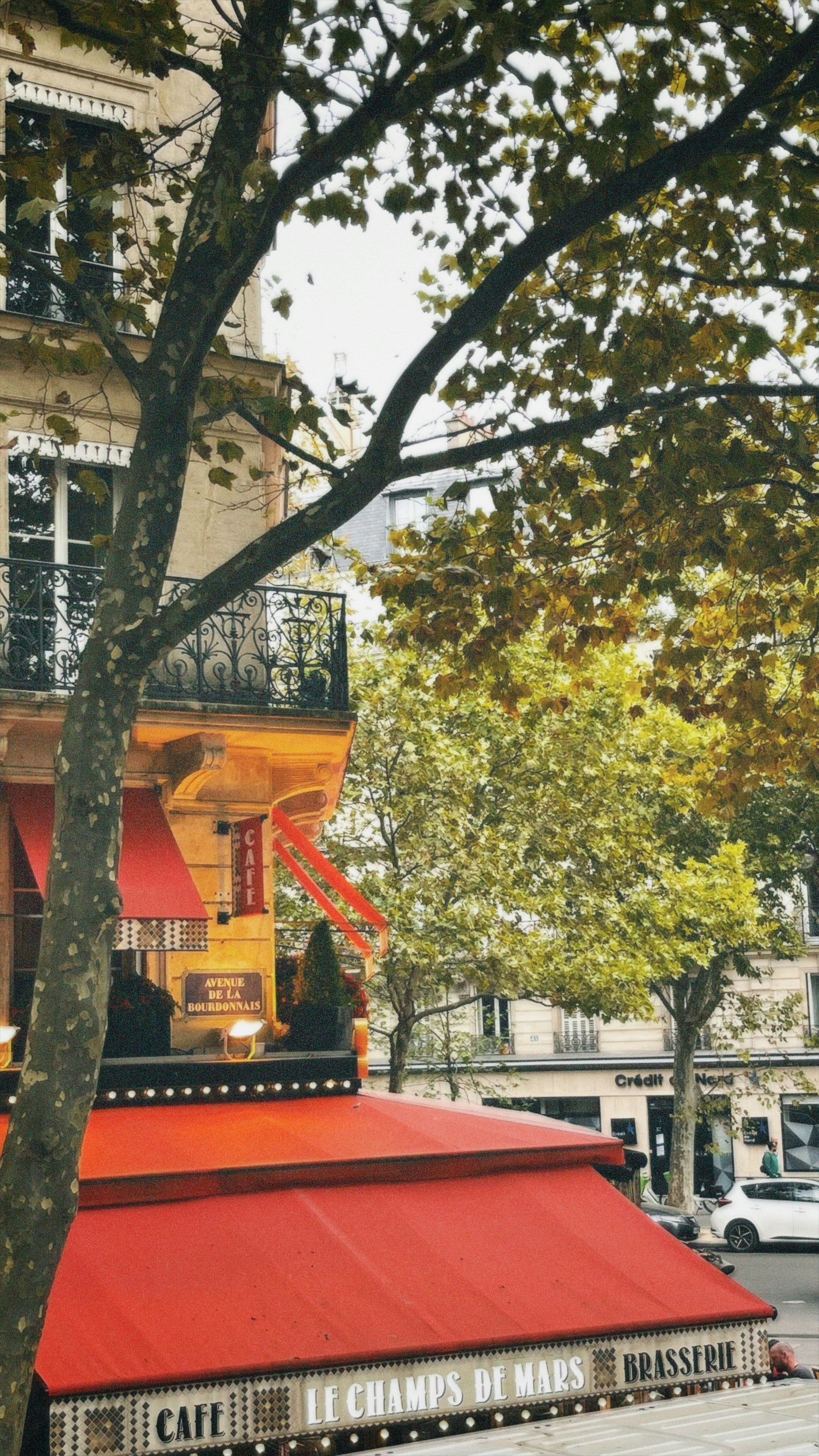 Sunlit Café Canopy on a Parisian Street