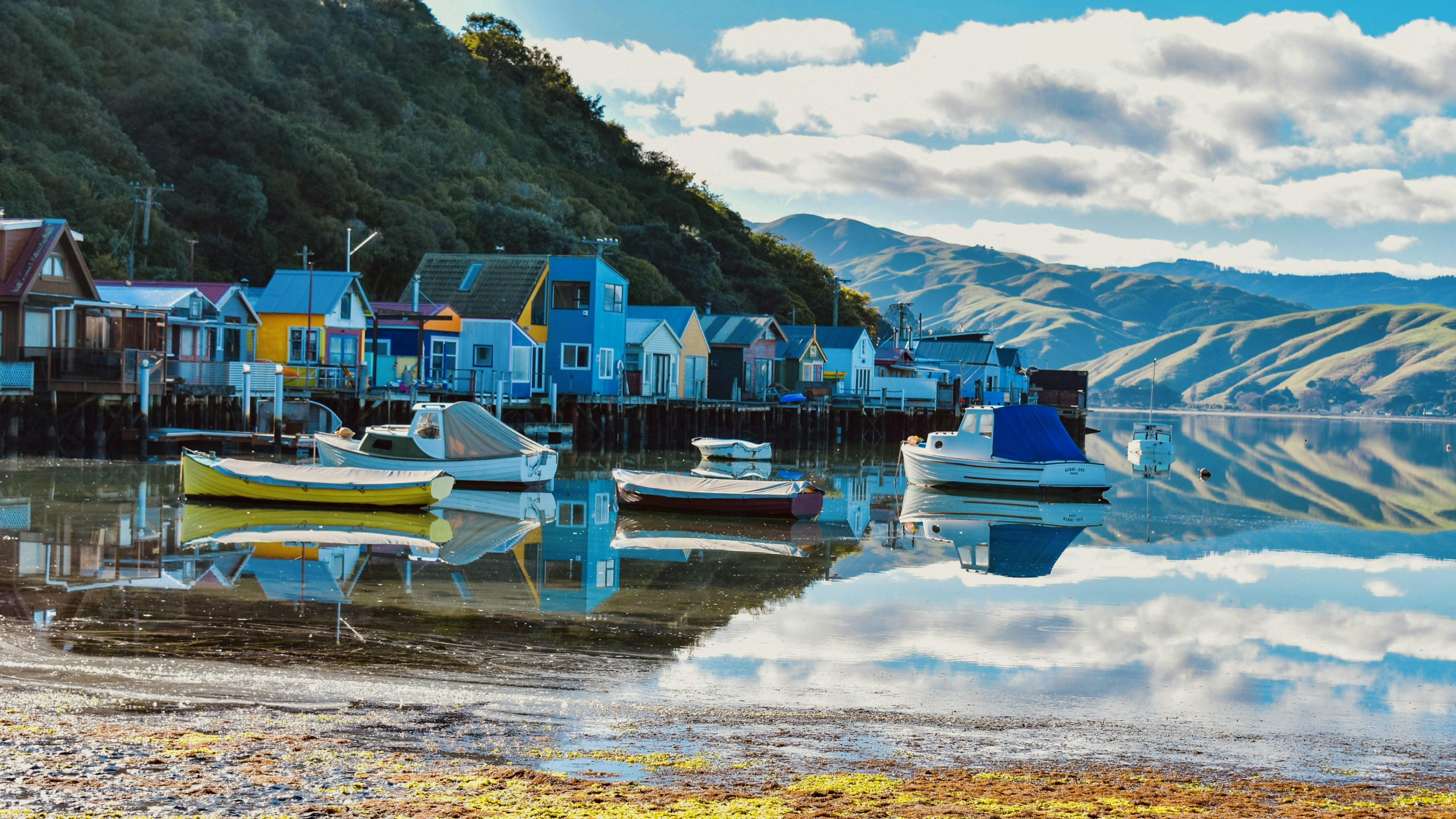 Colorful lakeside harbor mirrors a sky of geometric clouds