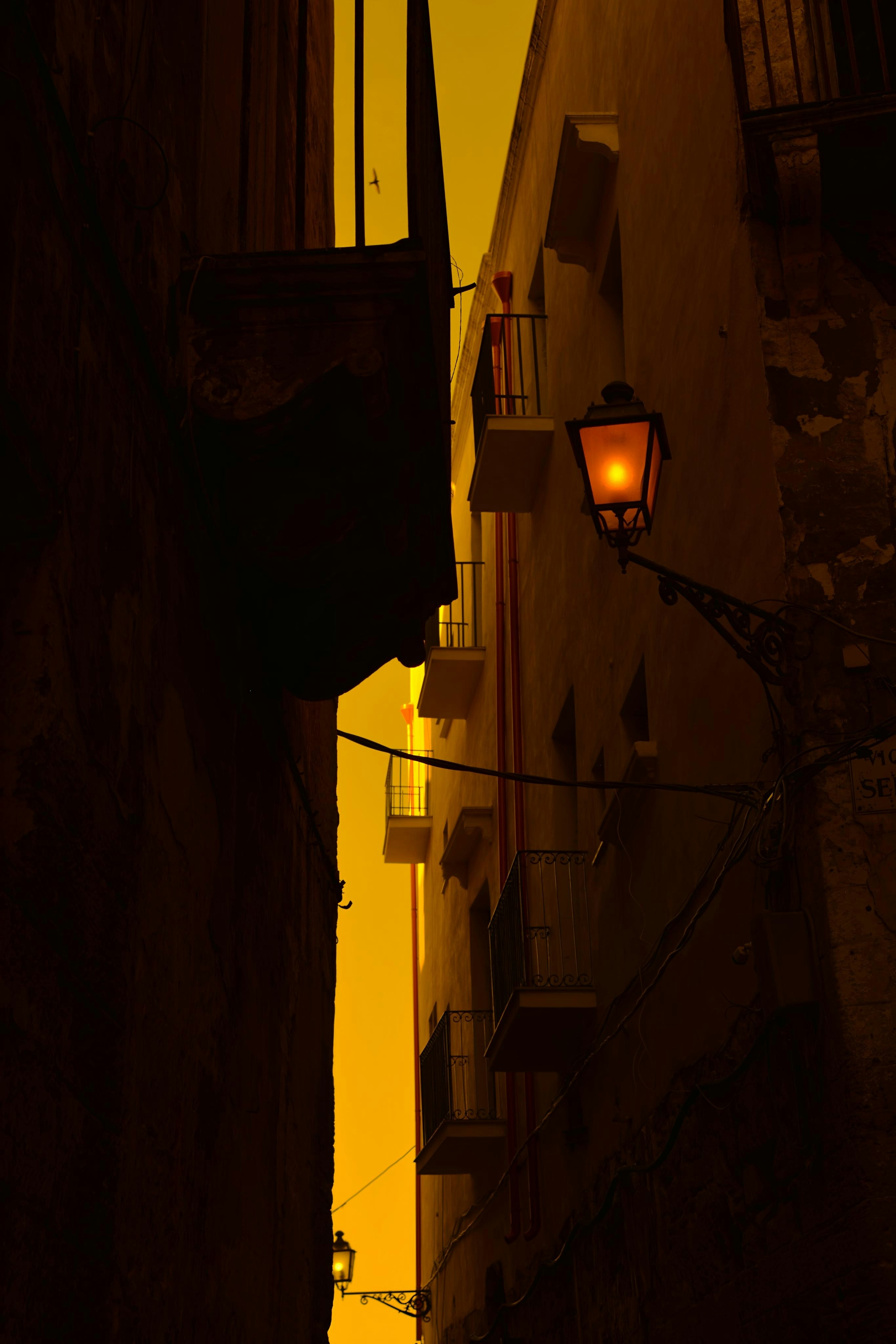 Narrow Alley at Dusk: Warm Glow Between Tall Walls