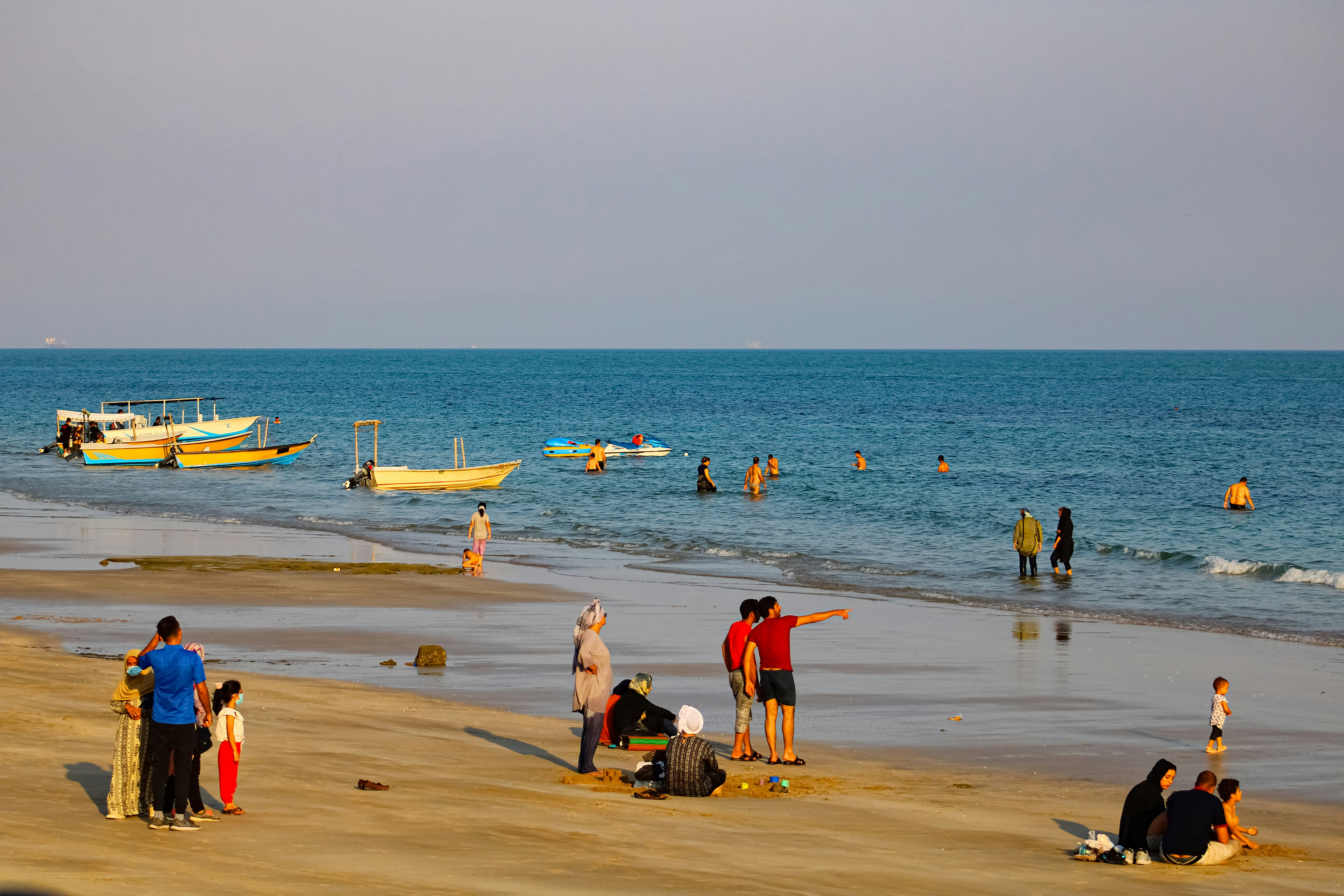 Sun-Kissed Beach Scene with Families and Boats At Dusk
