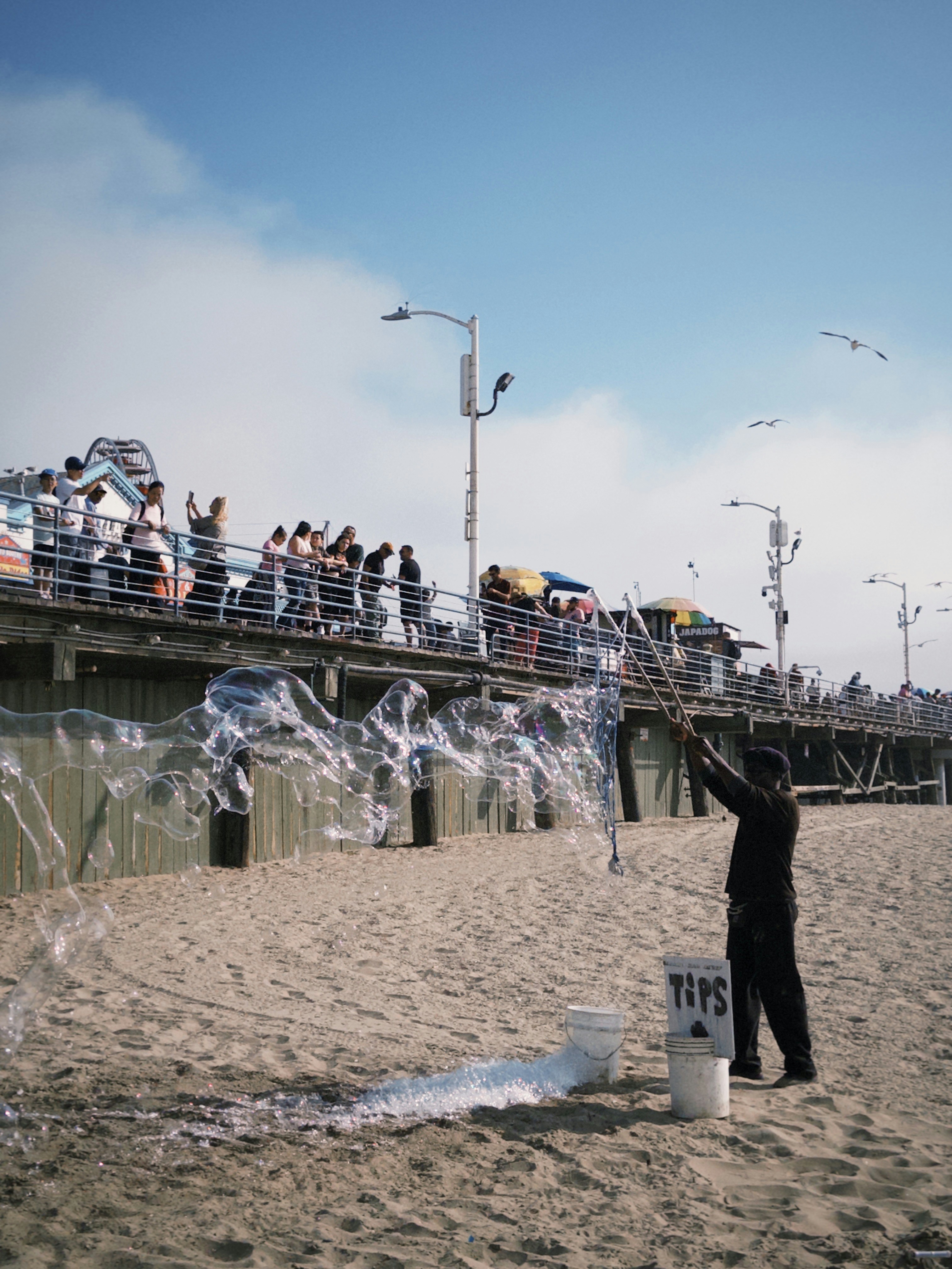 Bubble Artist on the Edge: A Beachside Performance Under the Pier