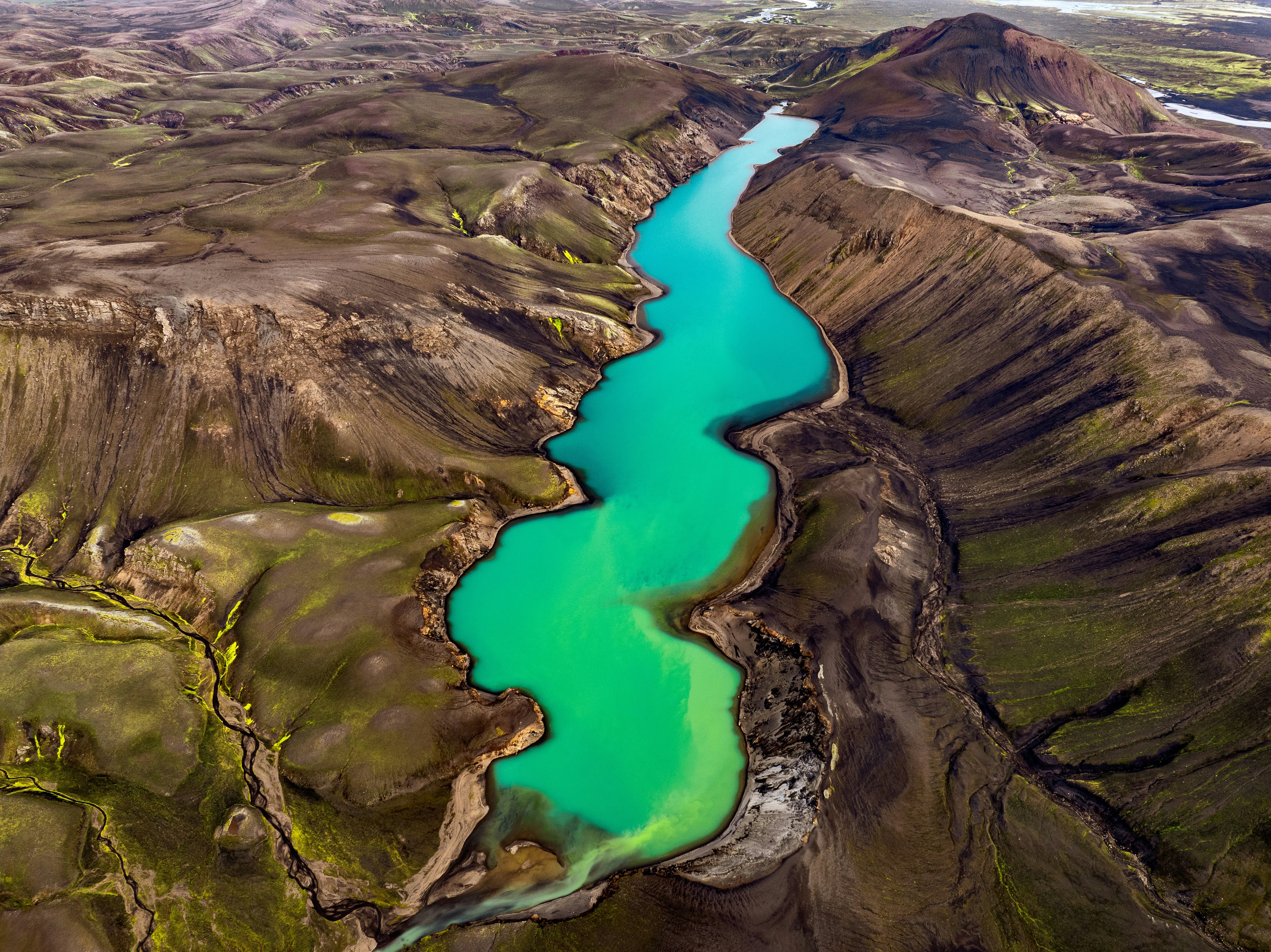 Turquoise Ribbon Through Volcanic Valleys