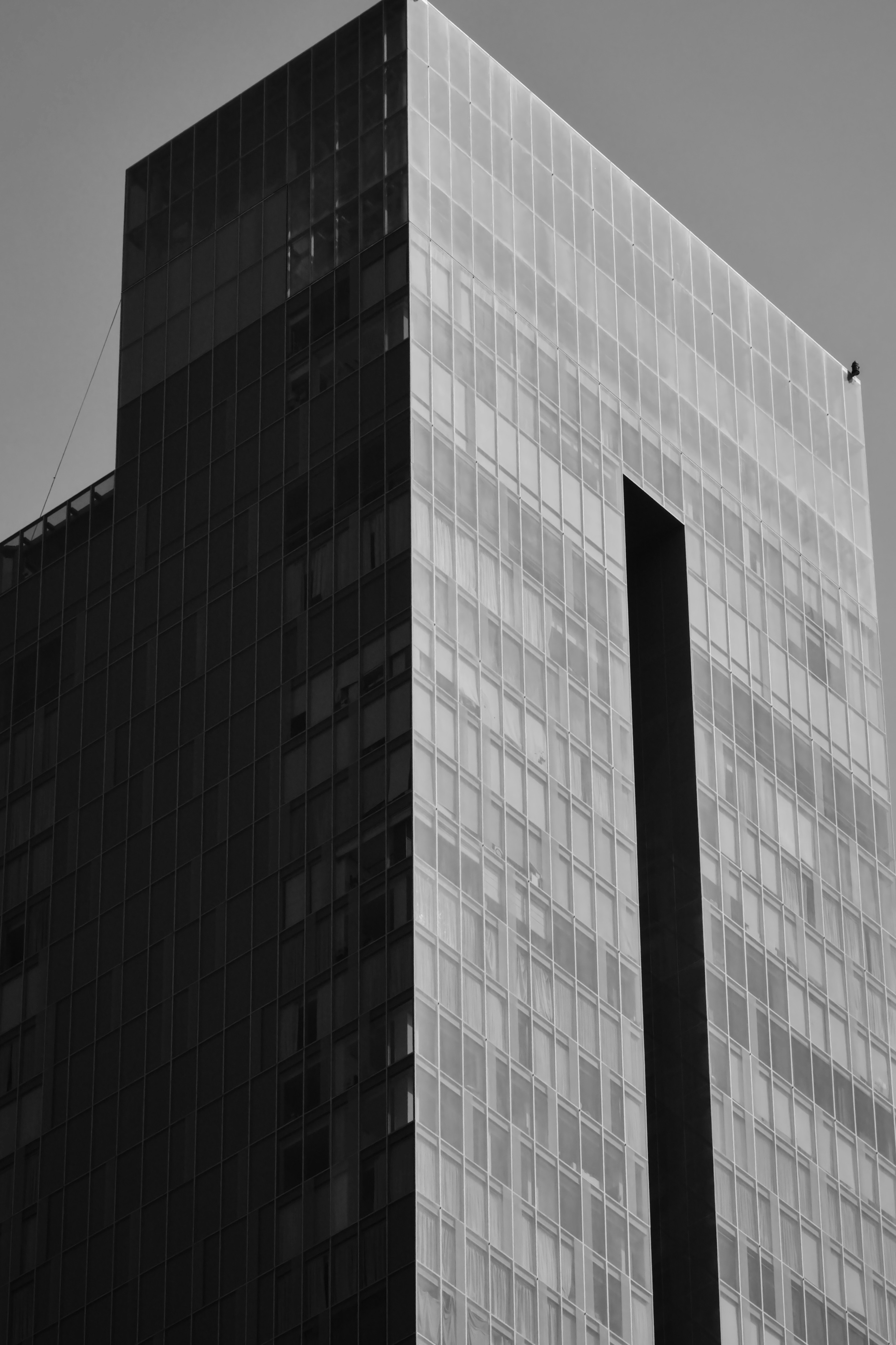 A Monolithic Facade: The L-shaped Glass Tower Cutting Through Light