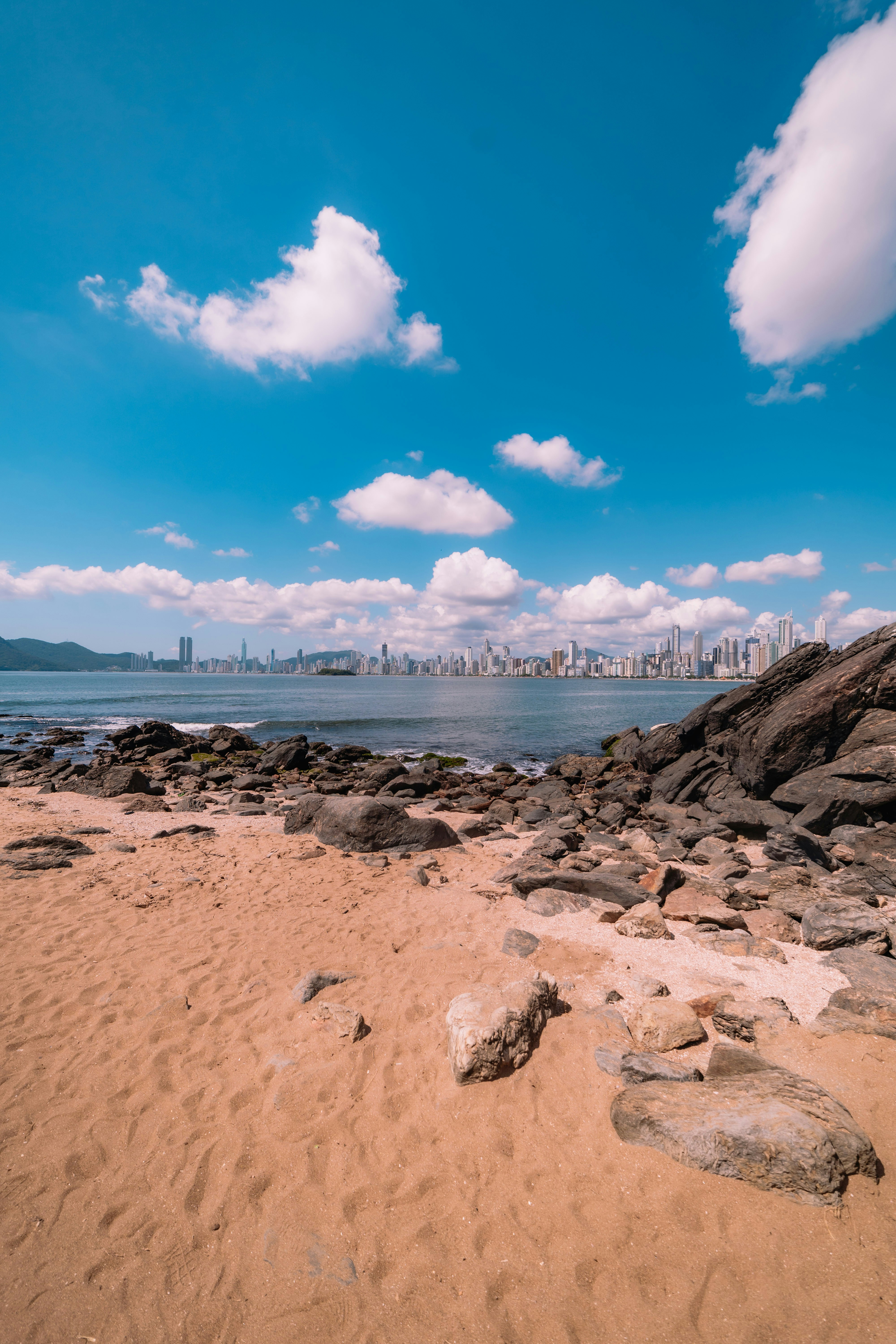 Coastal City Vista: Sands, Rocks, and Skyline