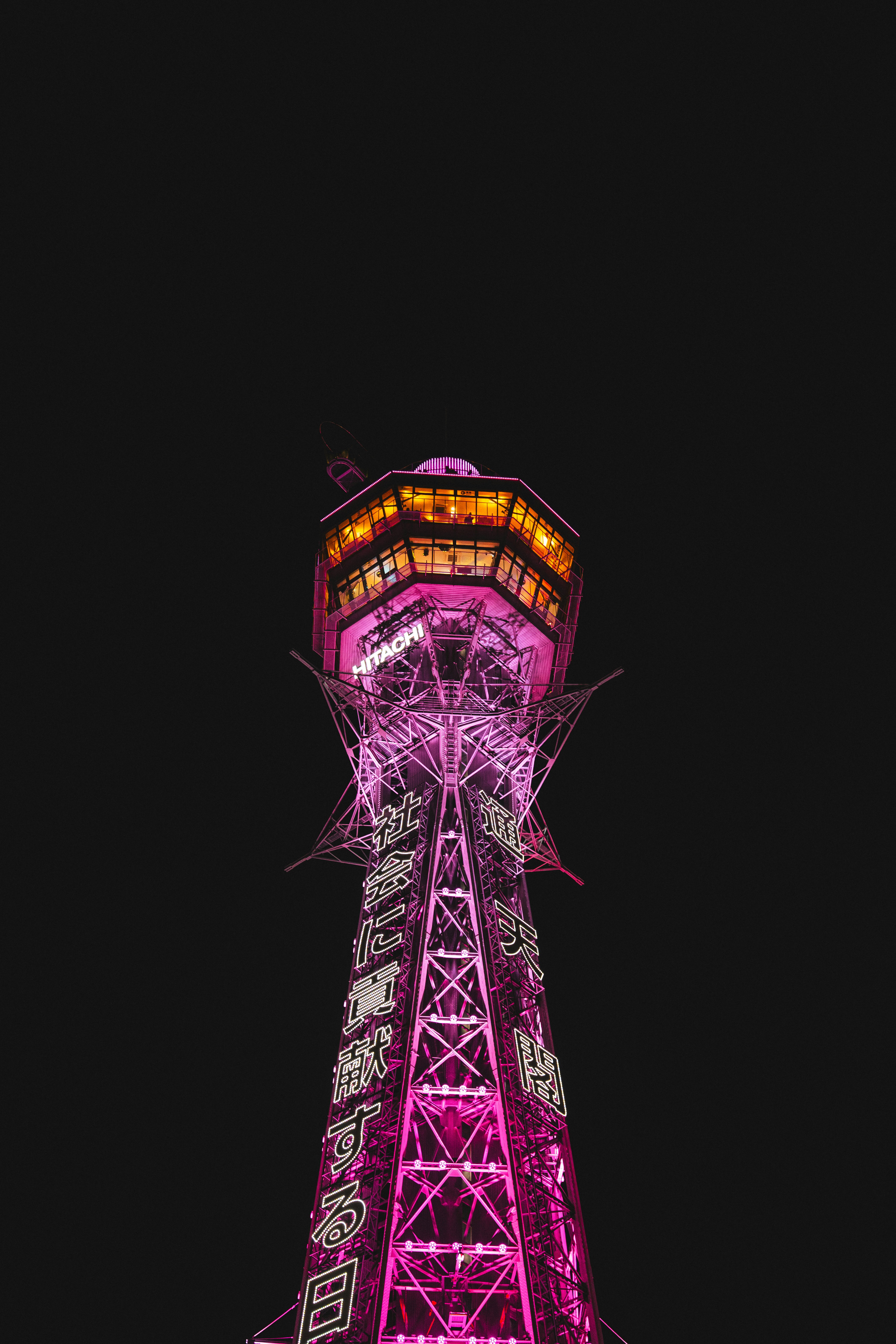 Neon-lit lattice tower piercing the night sky