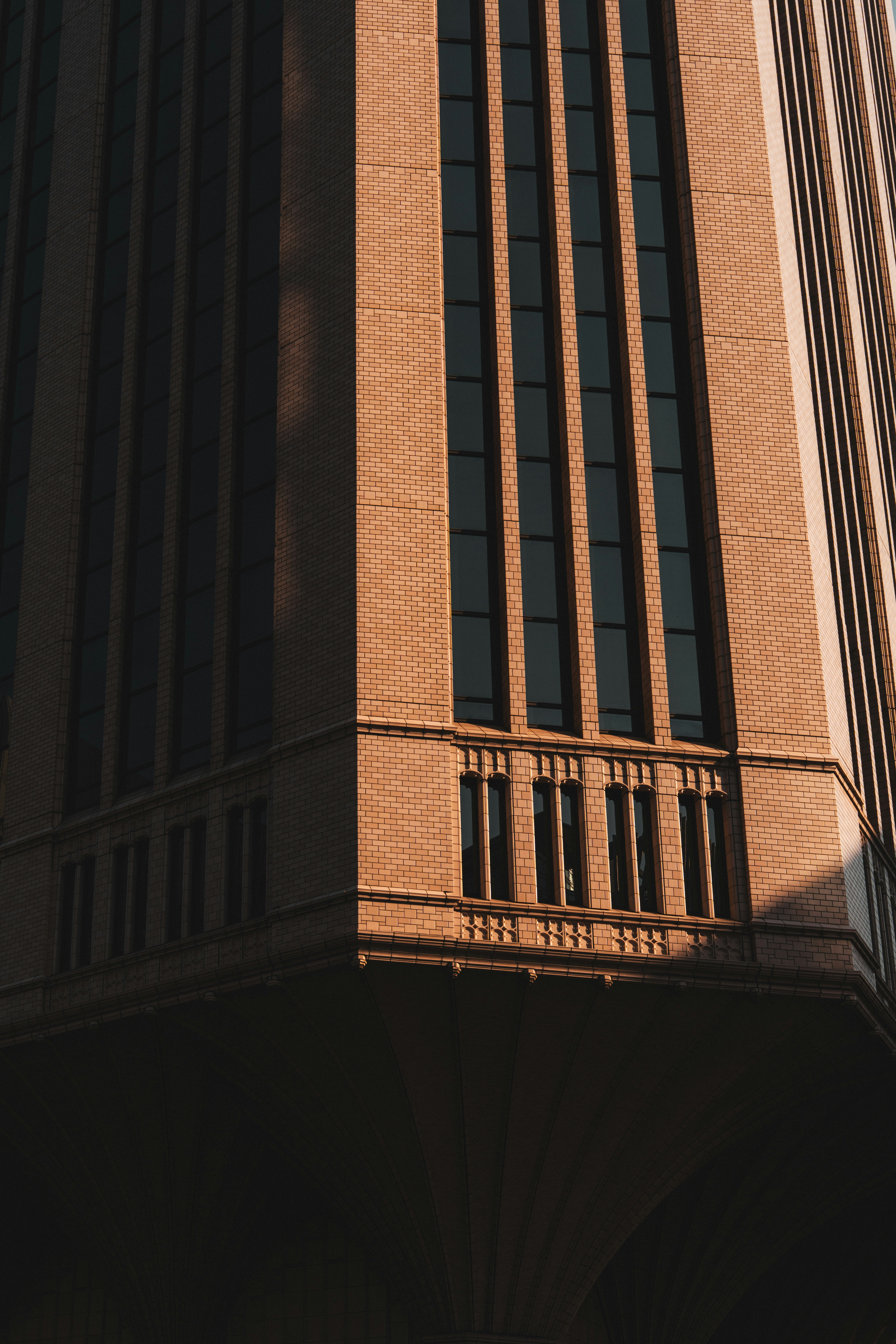 Brick Facade and Shadowed Corner of a Tall Architectural Tower