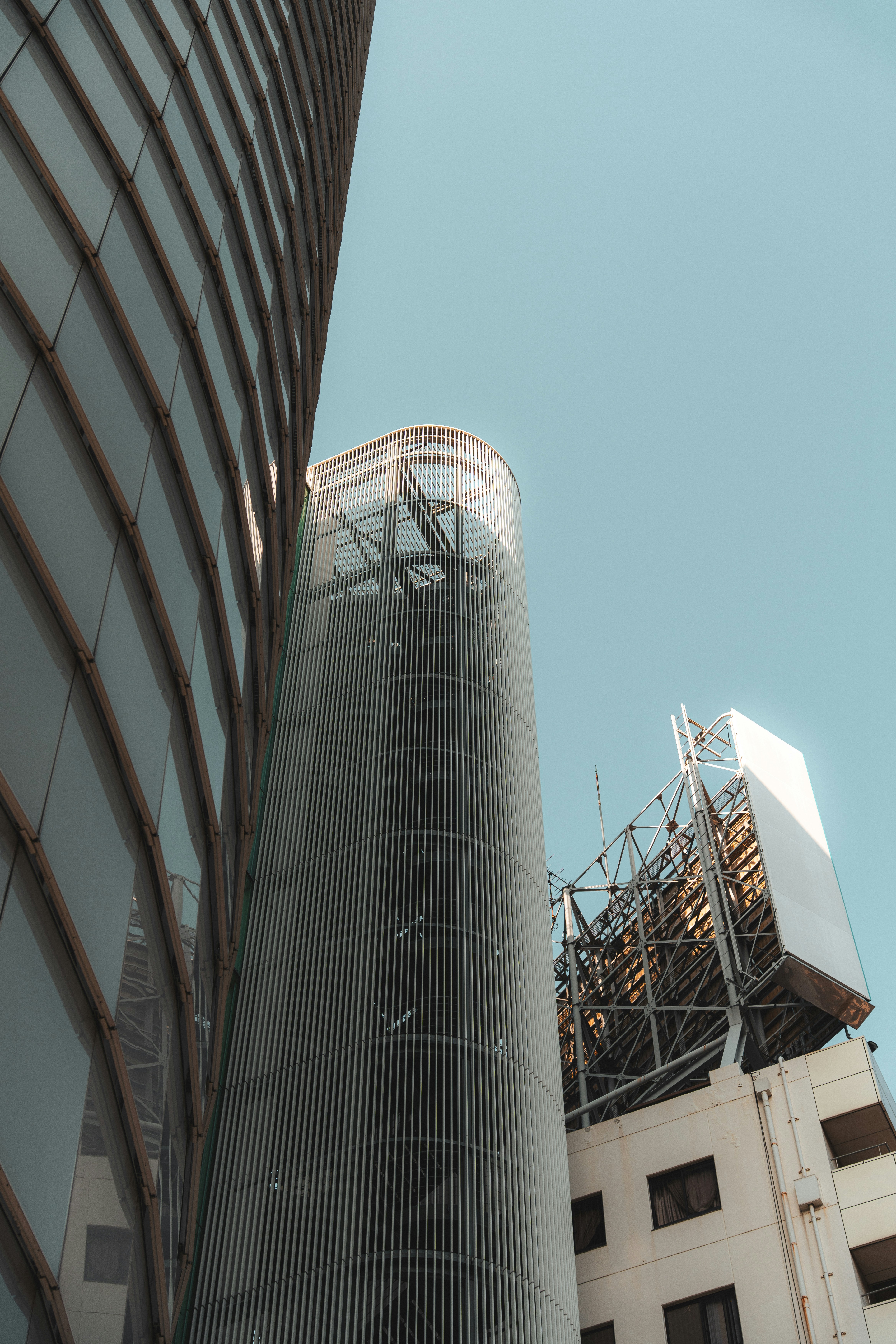 Curved Glass Tower Rising Amid Urban Skeletons