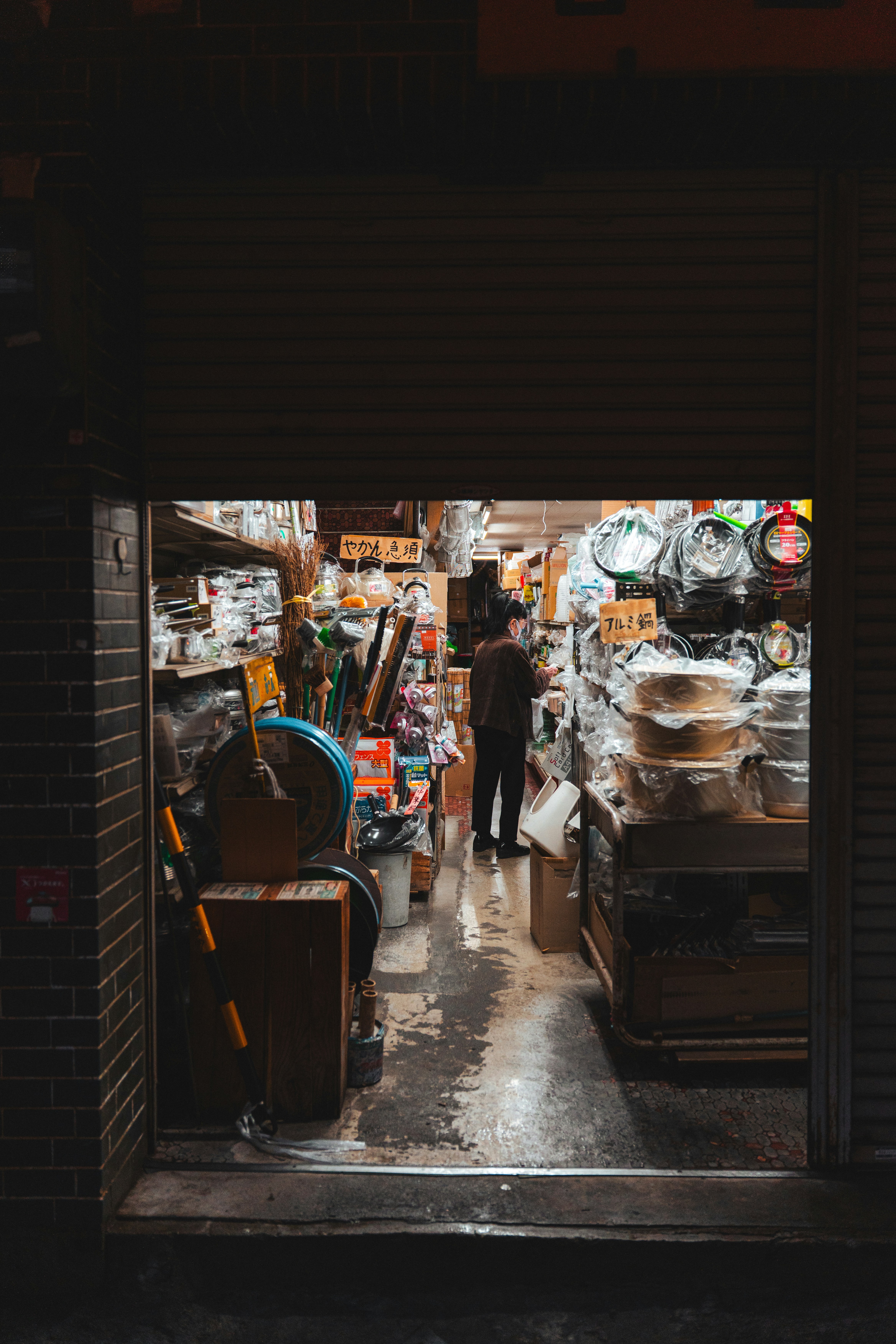 A Quiet Moment in a Bustling Market: Worker among Piled Goods