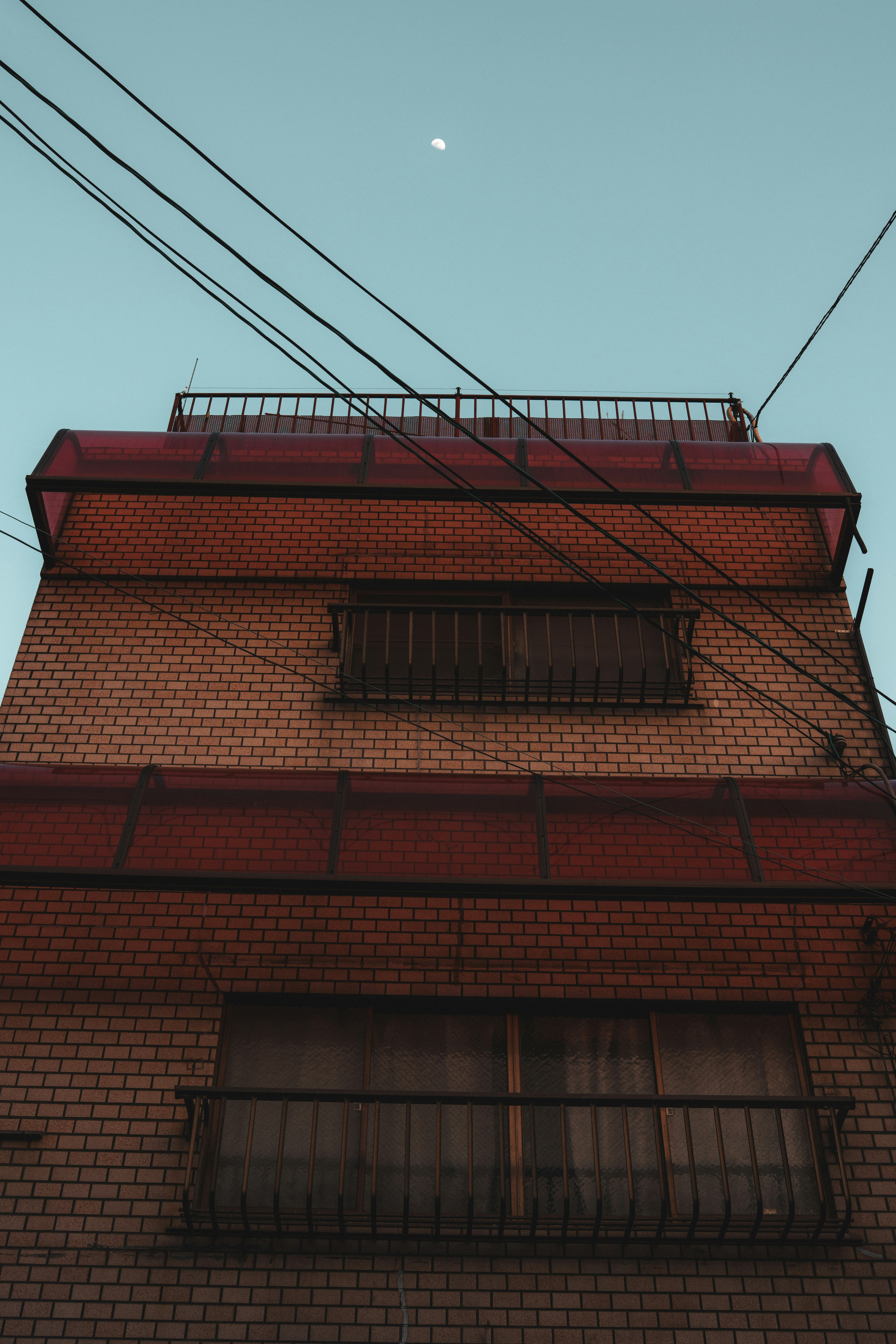 Brick Facade Under a Clear Sky with Overhead Cables