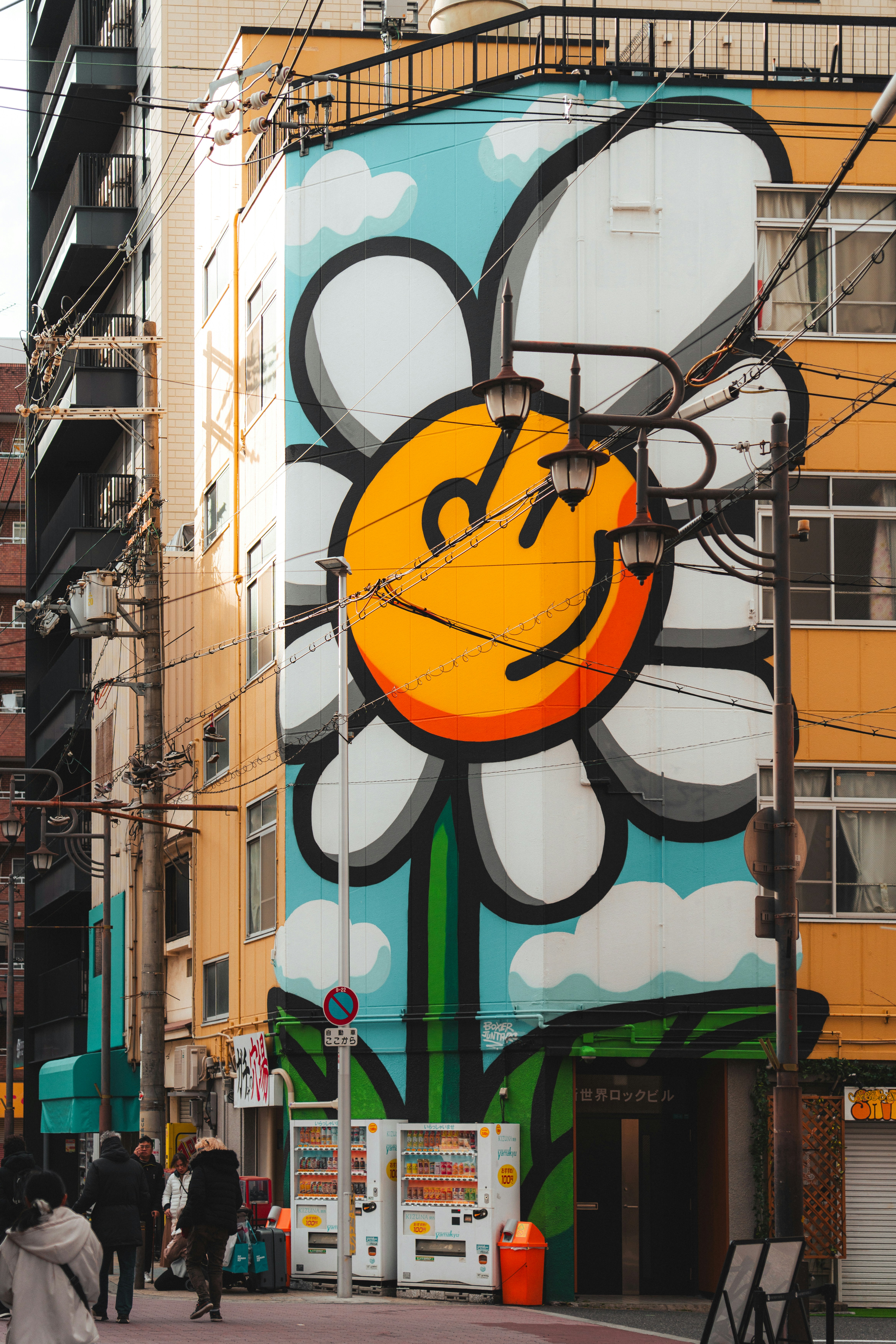 Urban mural: a towering daisy face peppers the street