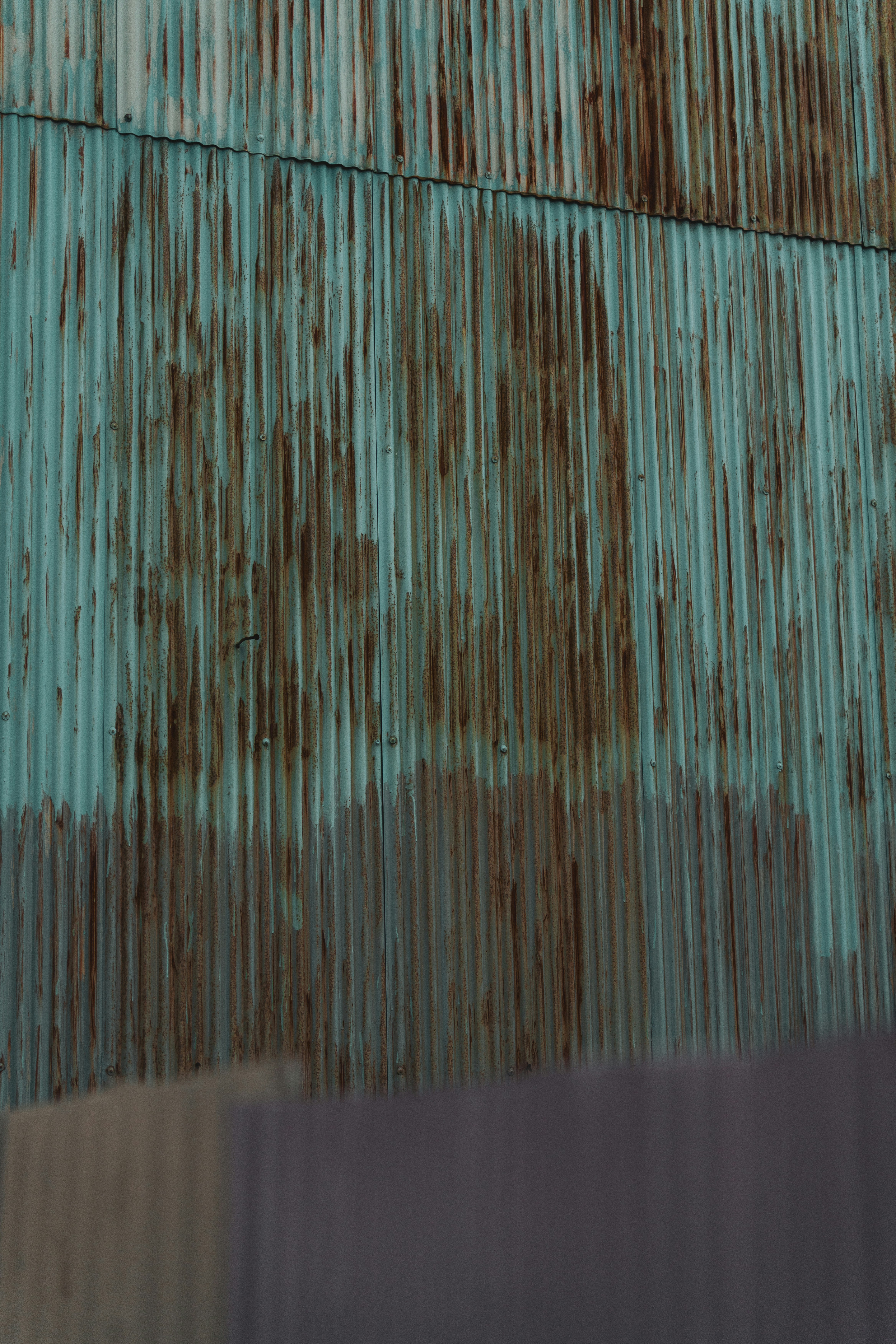 Rusting Teal Corrugation: Vertical Stains on Weathered Metal