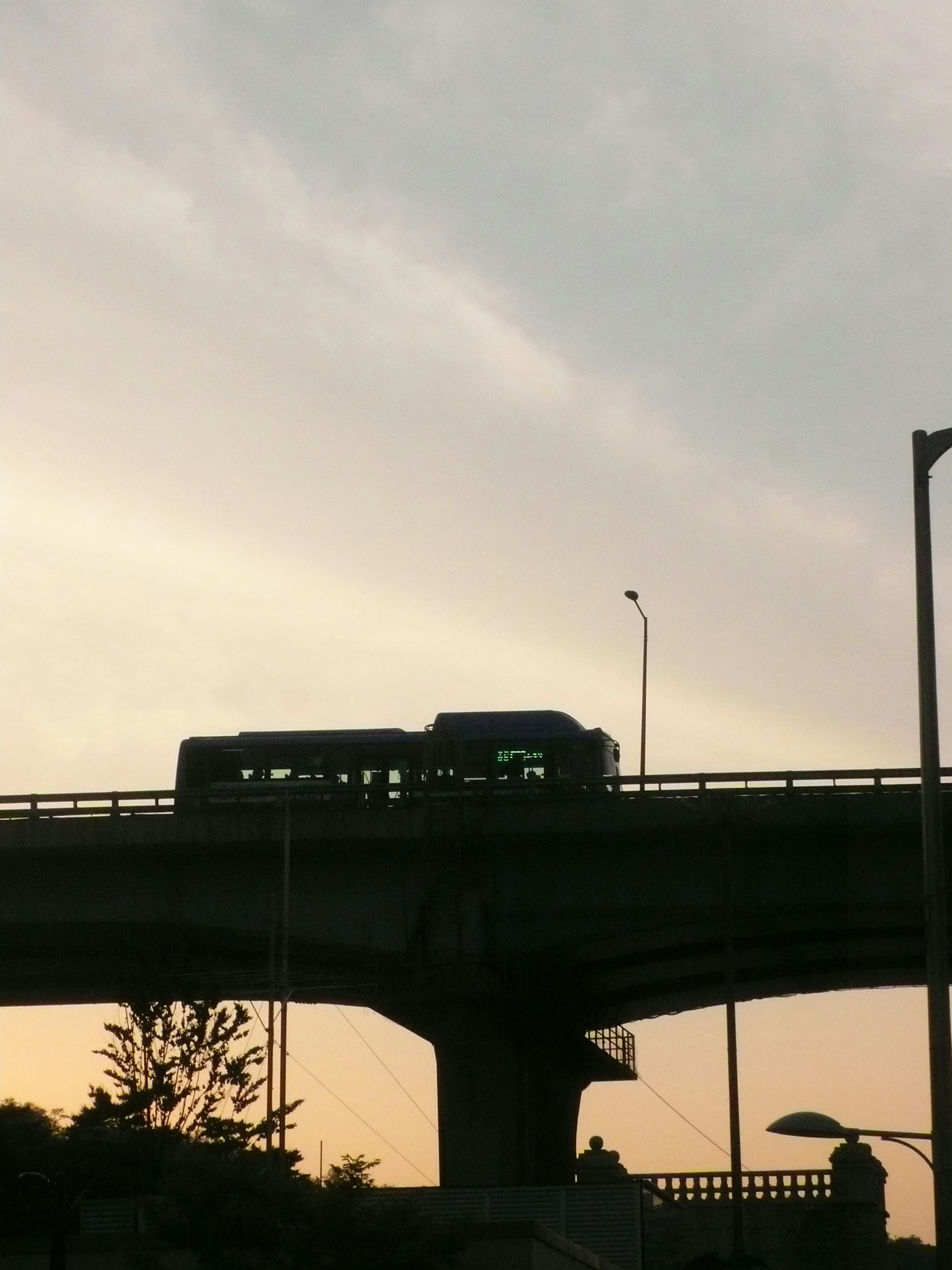 Lone Bus Silhouette Crossing a Sunset Bridge