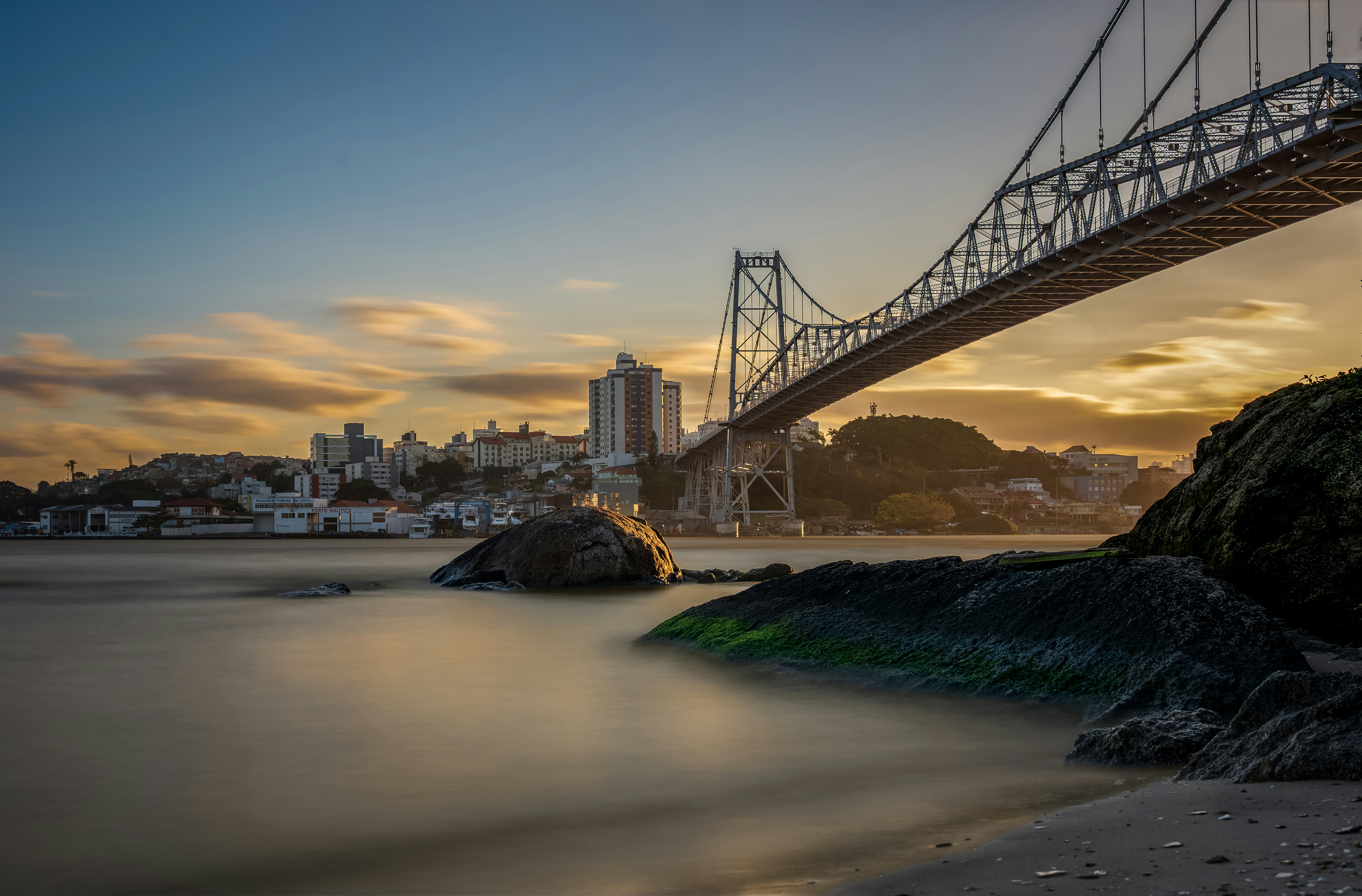 Golden Hour Span: A City Bridge Over Calm Tides