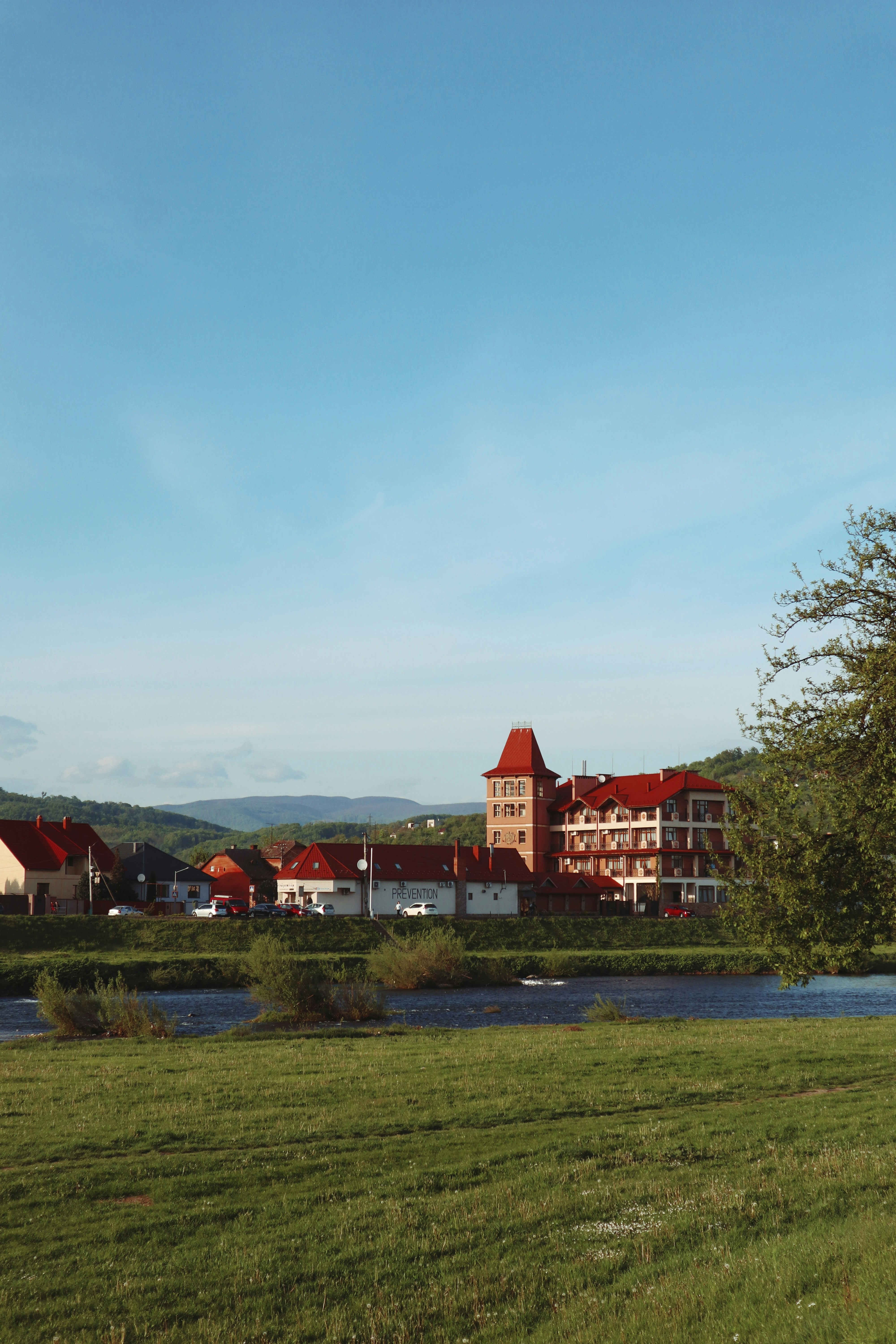 Village by the Meadow under a Clear Blue Sky