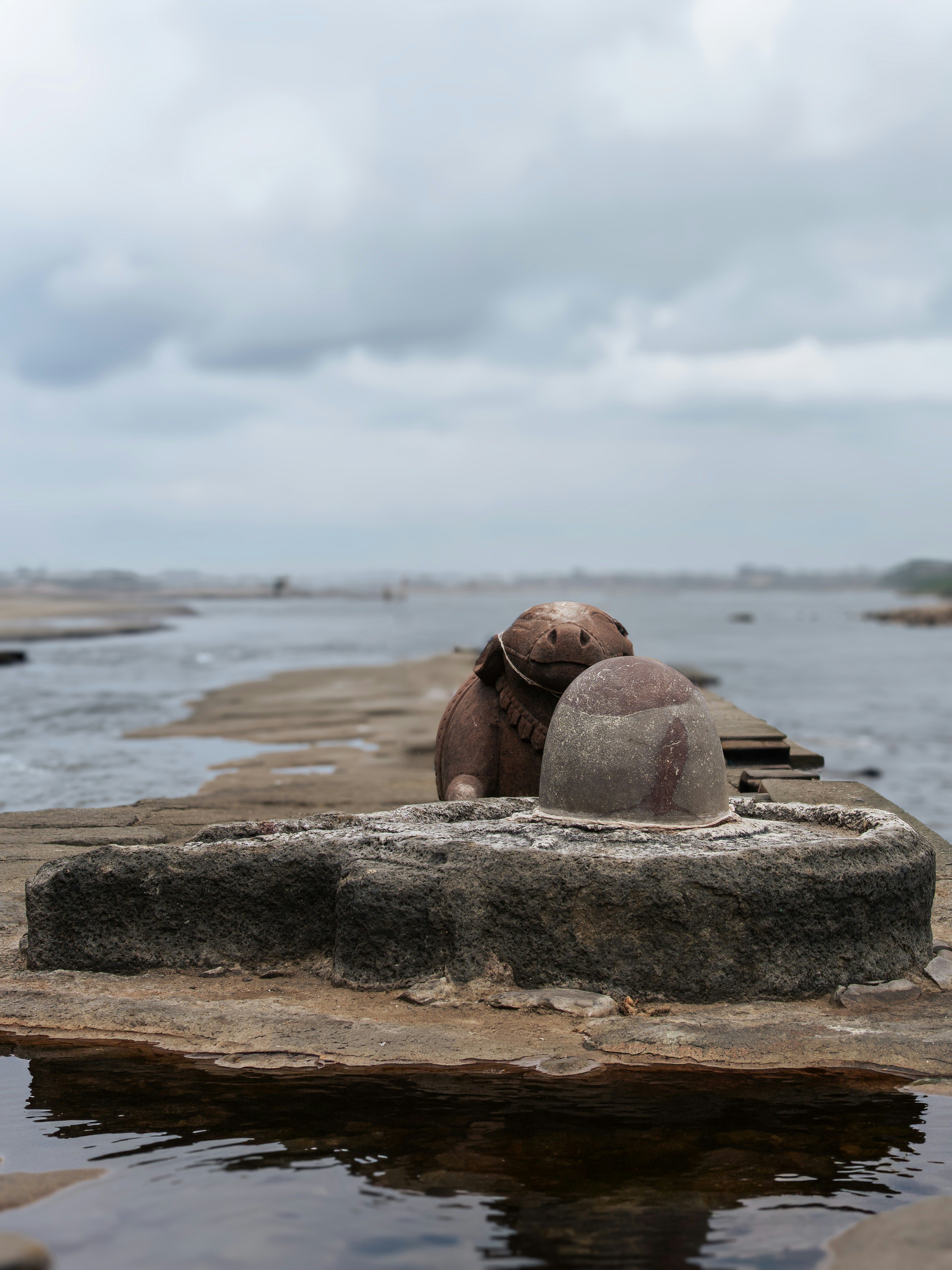 Stone Sentinel at the Shoreline: Weathered Figures guarding the Quiet Channel