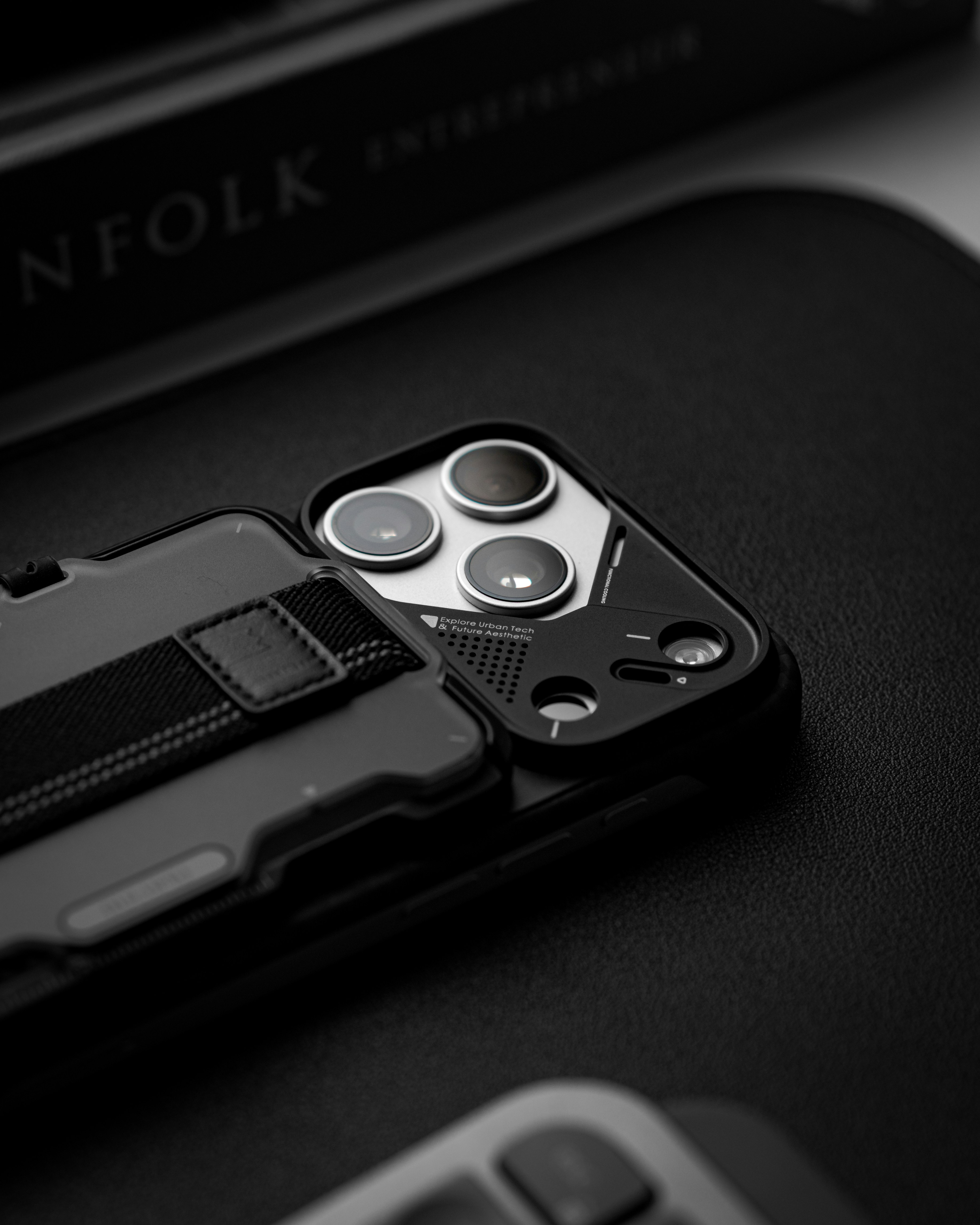 Close-up of a smartphone with its camera module exposed, resting on a dark surface for a moody, product-detail shot.