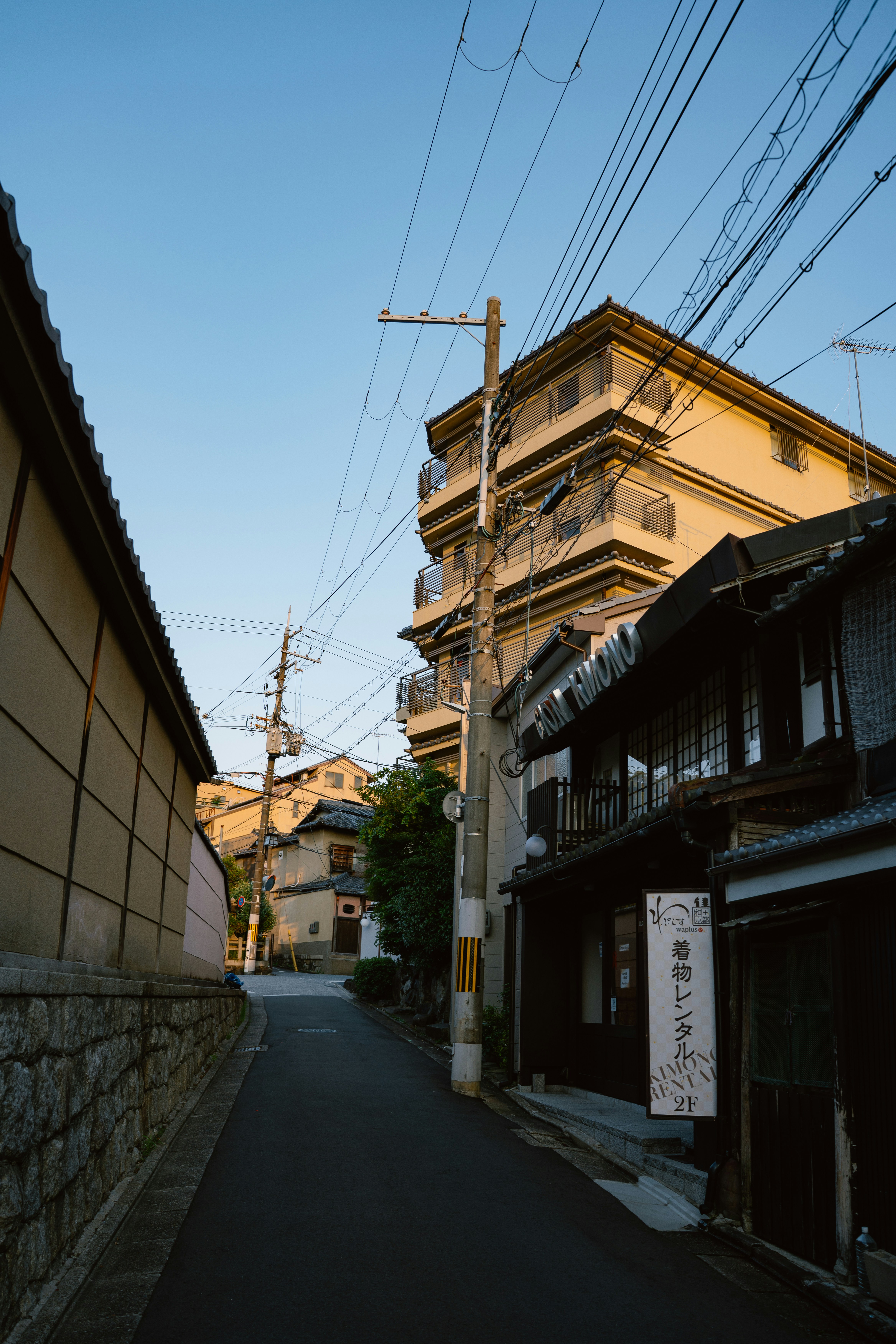 Narrow Street Under Power Lines with a Layered Building Facade