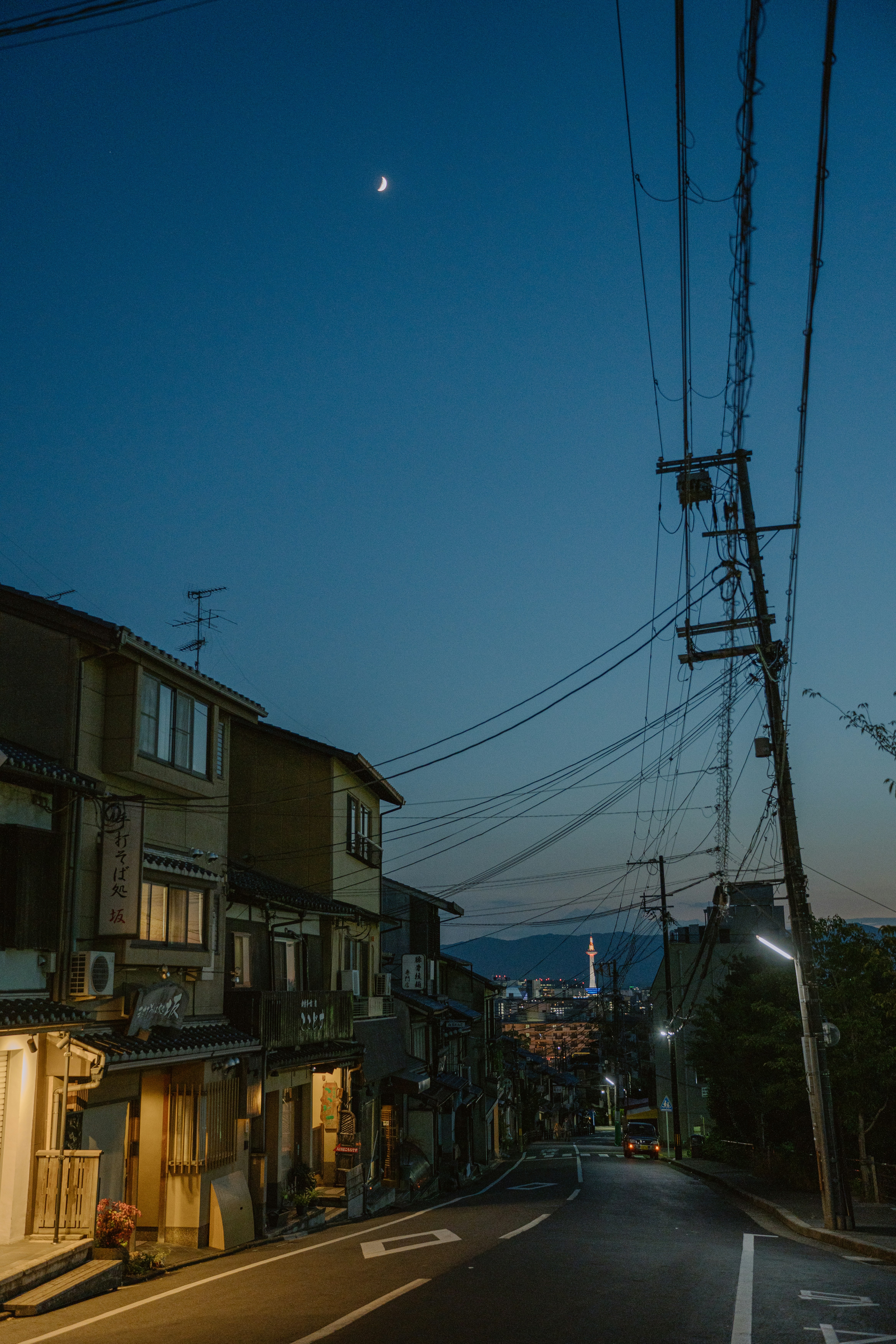 Evening Street in Quiet Neighborhood Under a Crescent Moon