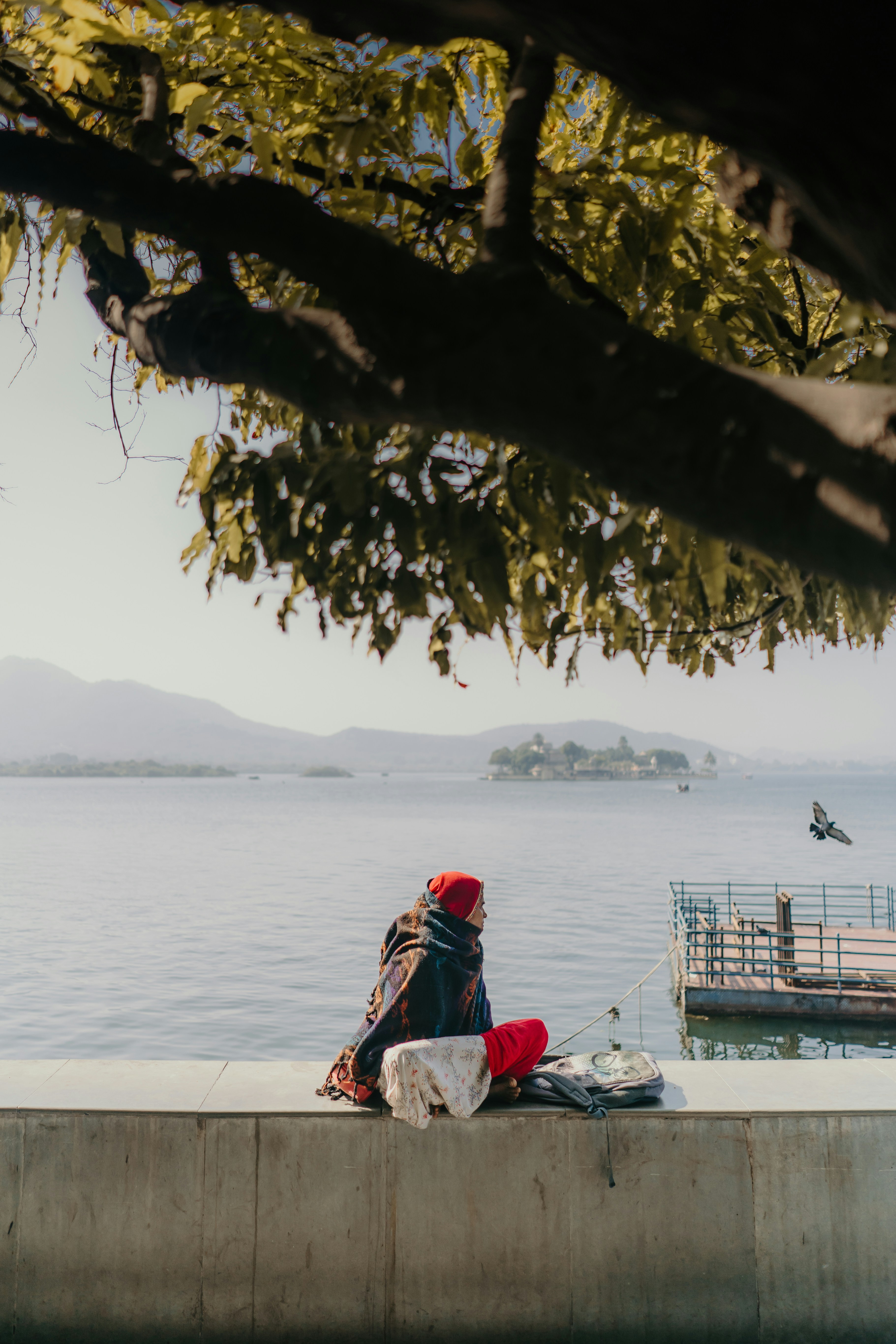 Red-clad Seeker at the Waterfront: A Quiet Moment by the Pier