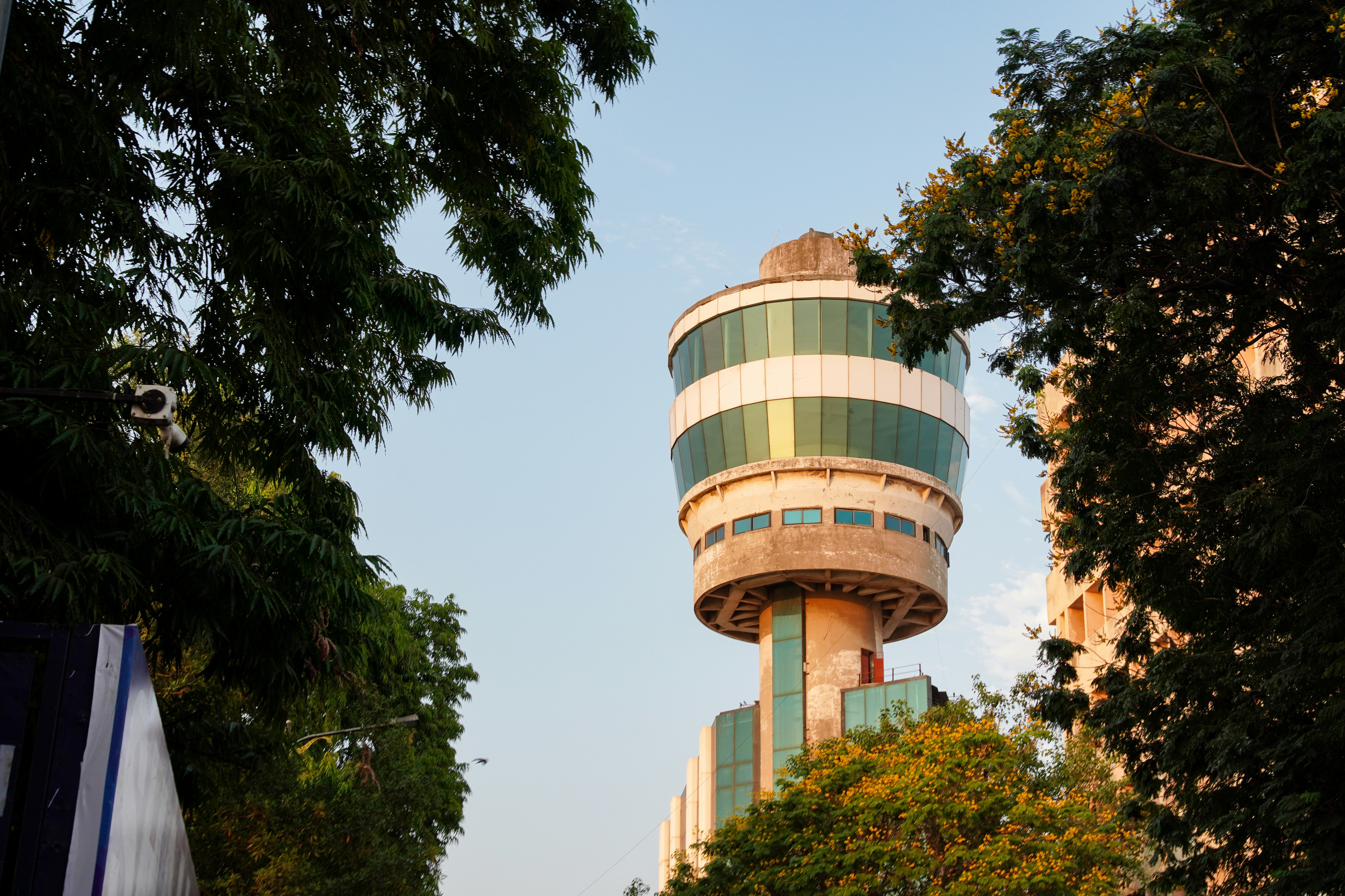 Circular Skyward: A Towering Control Circuit Amid Urban Foliage