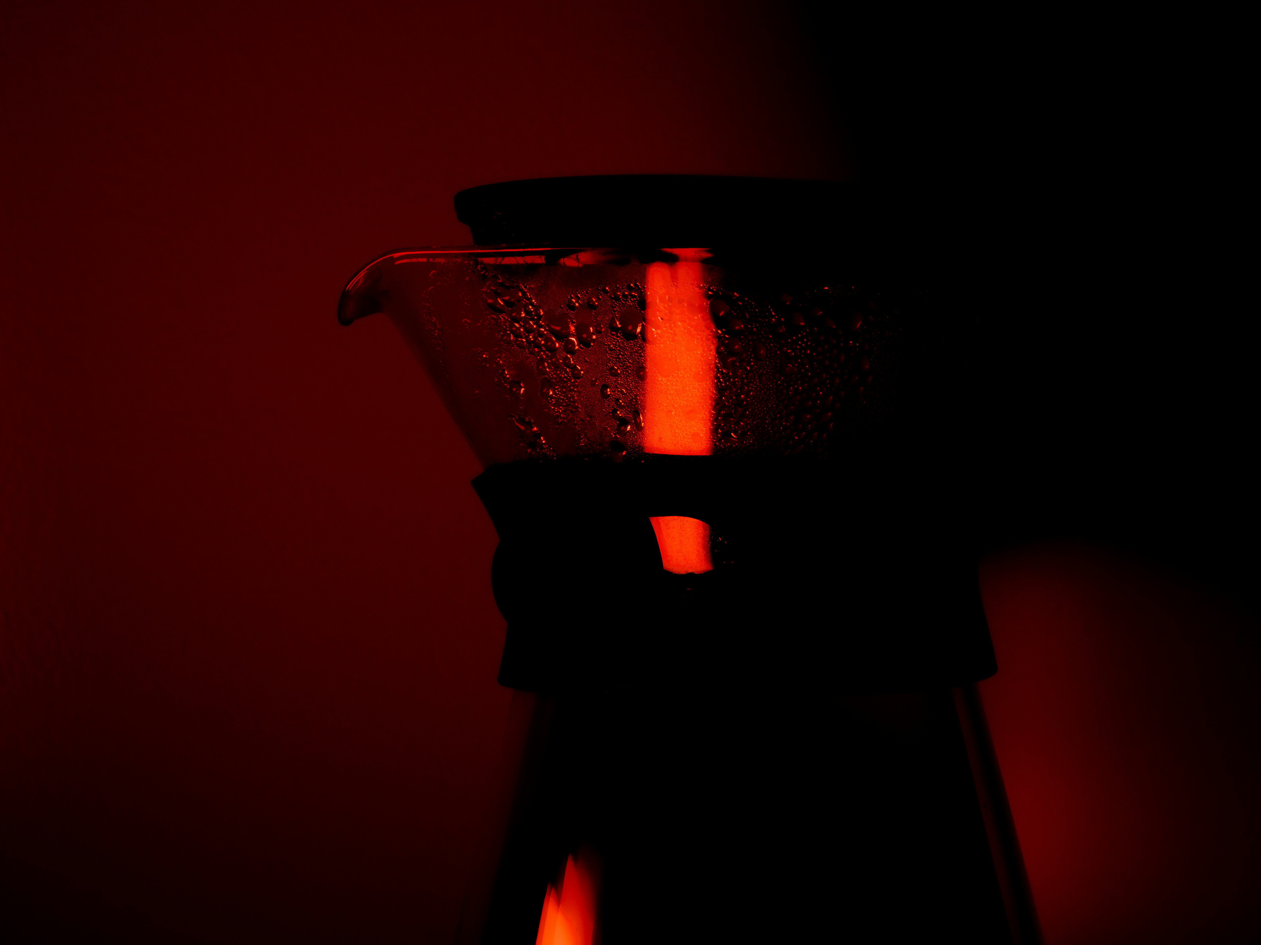 Crimson Steam: A Close-Up of a Glowing Kettle Lid in Dim Light
