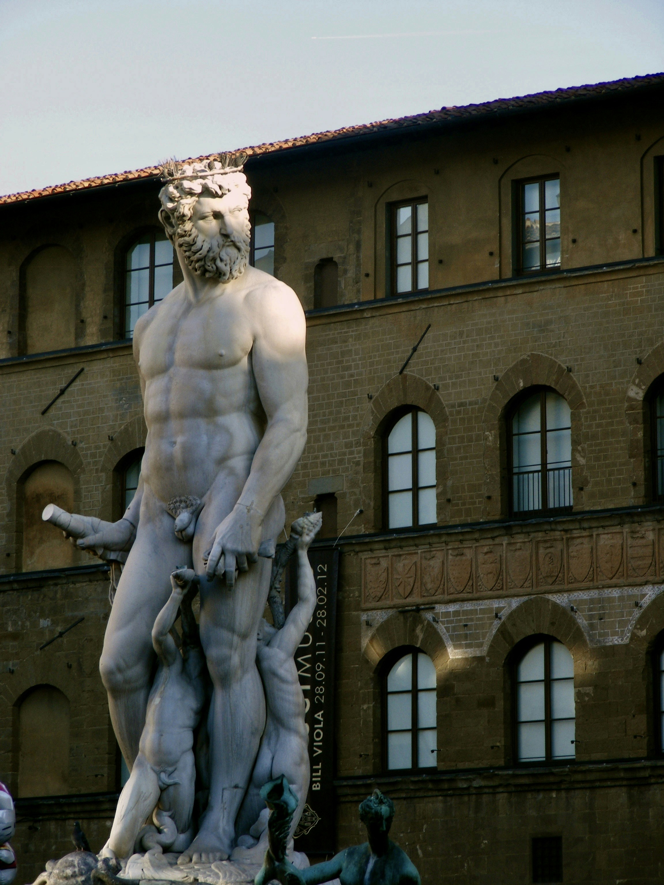 Giant in Marble: A Classical Statue Framed by Historic Facade