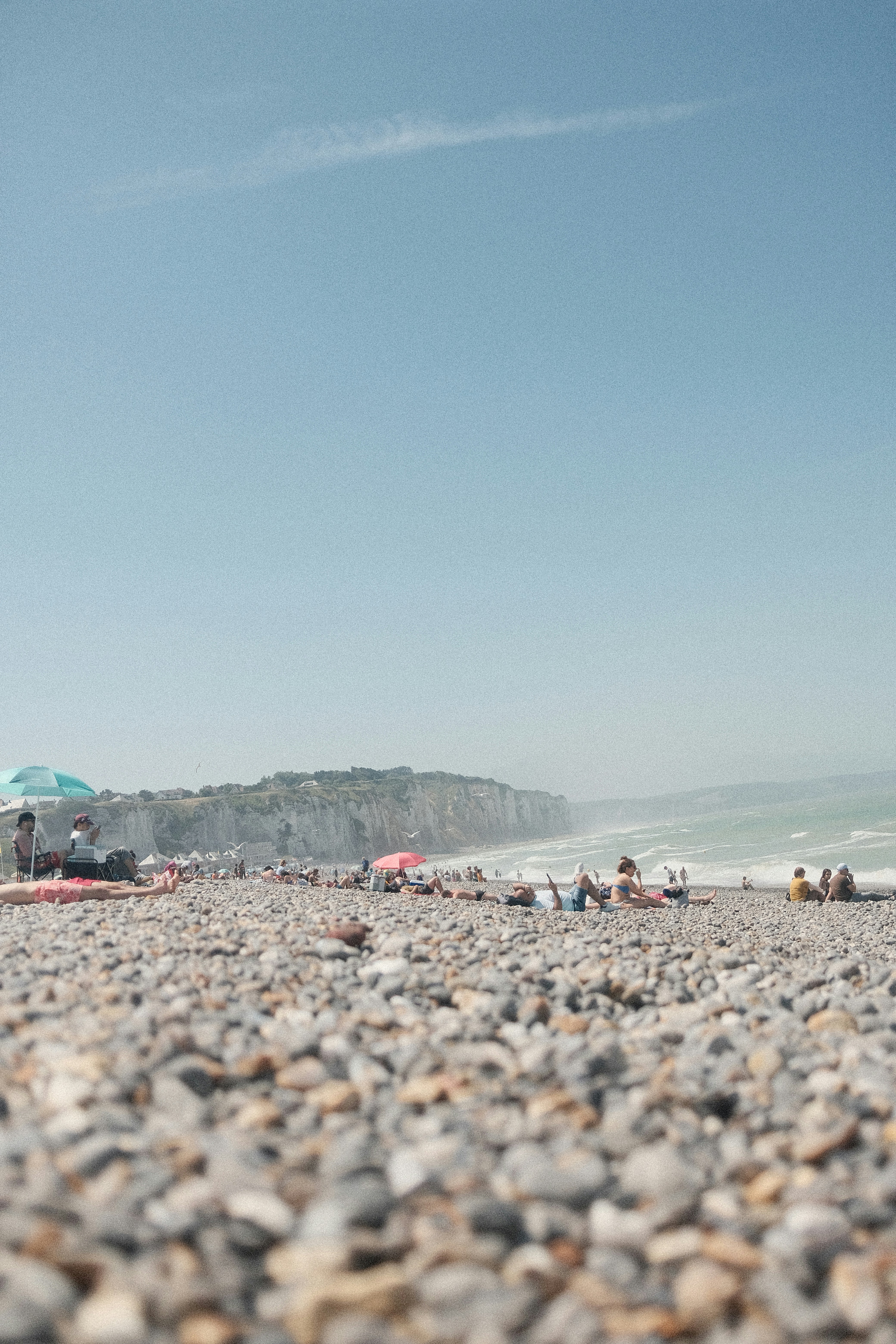 Pebble-strewn shoreline under a broad coastal horizon