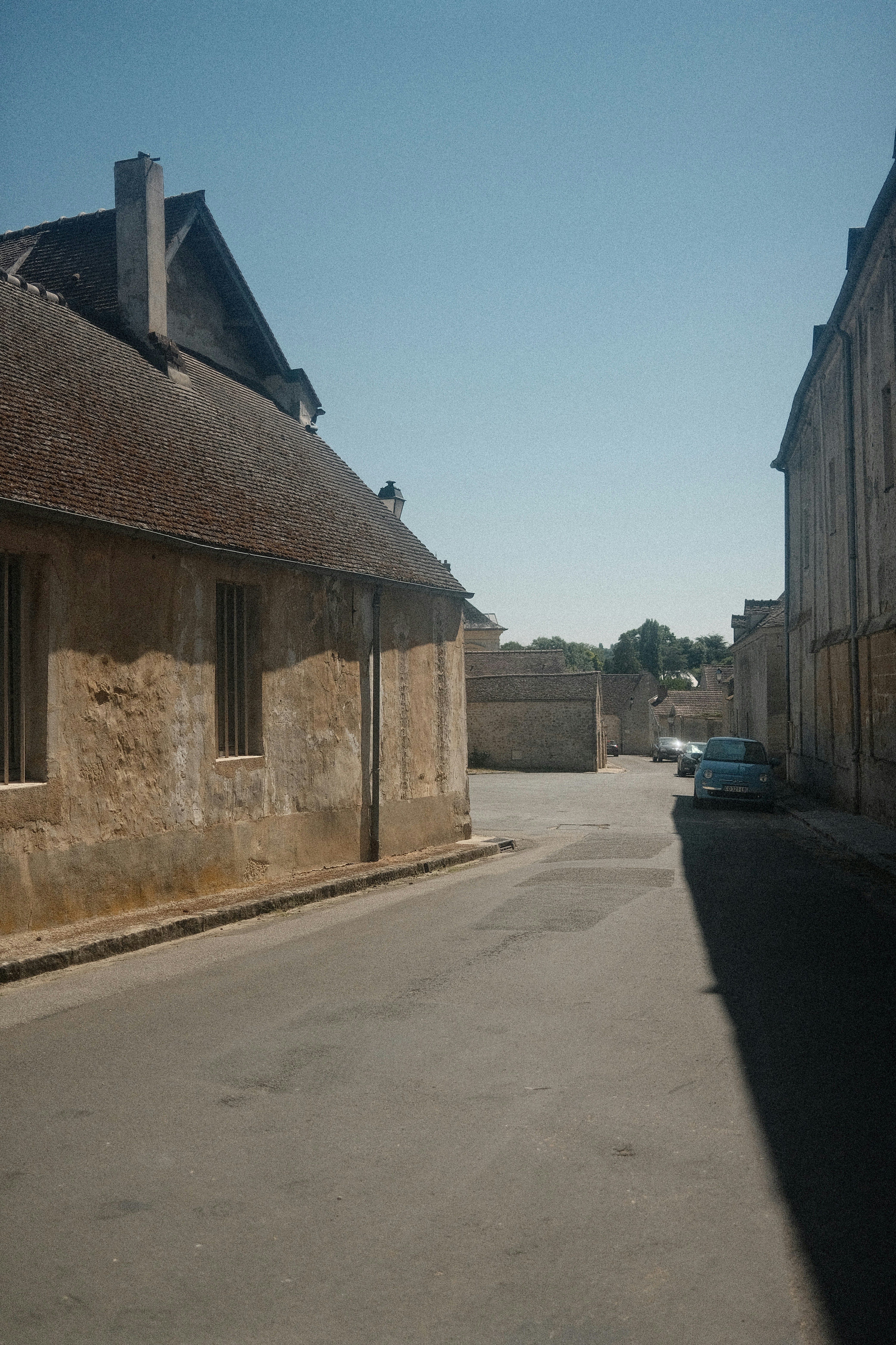 Sunlit Street through Old Stone Facades