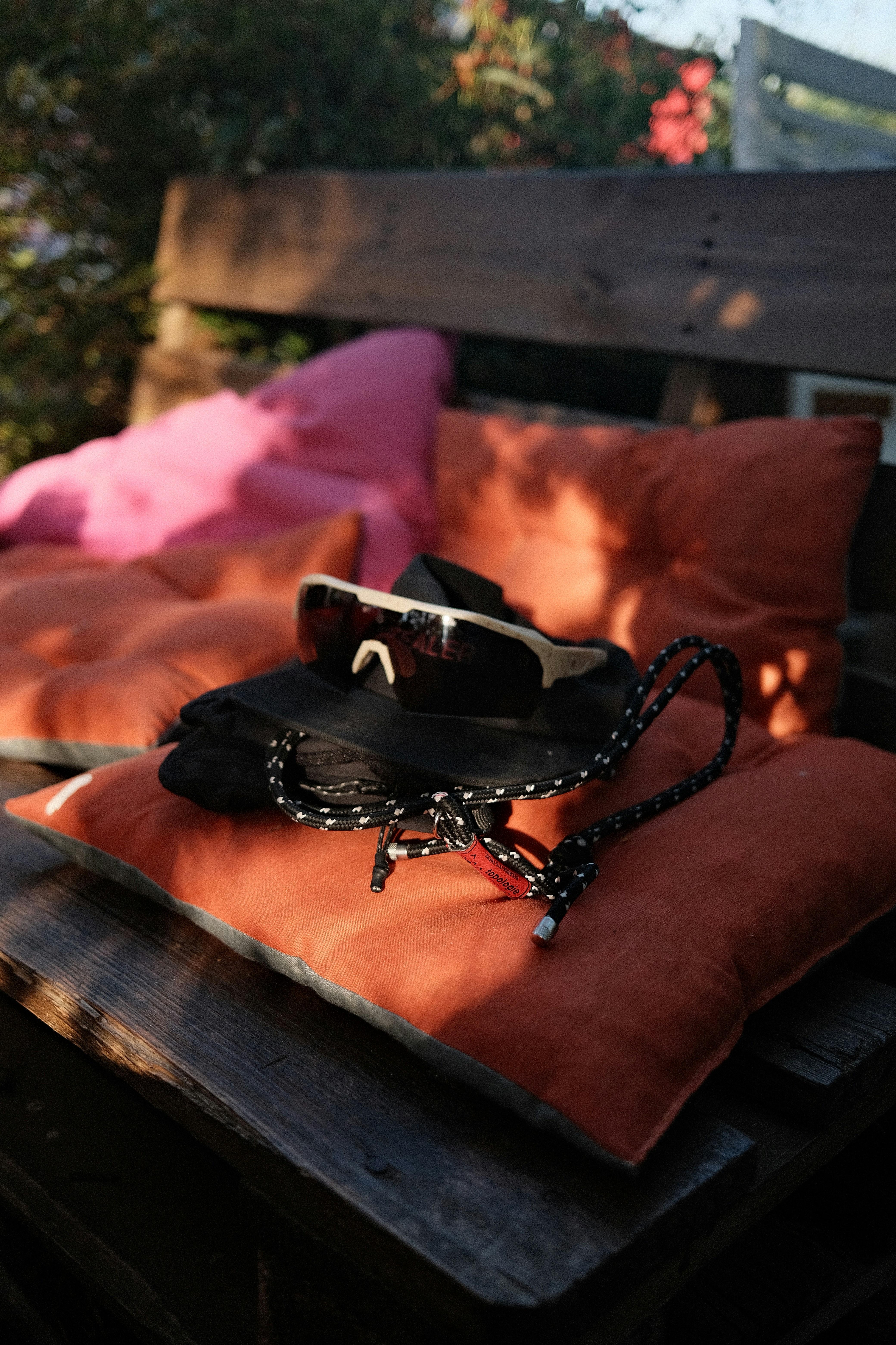 Sunglasses and Rope on Weathered Cushions in Afternoon Light
