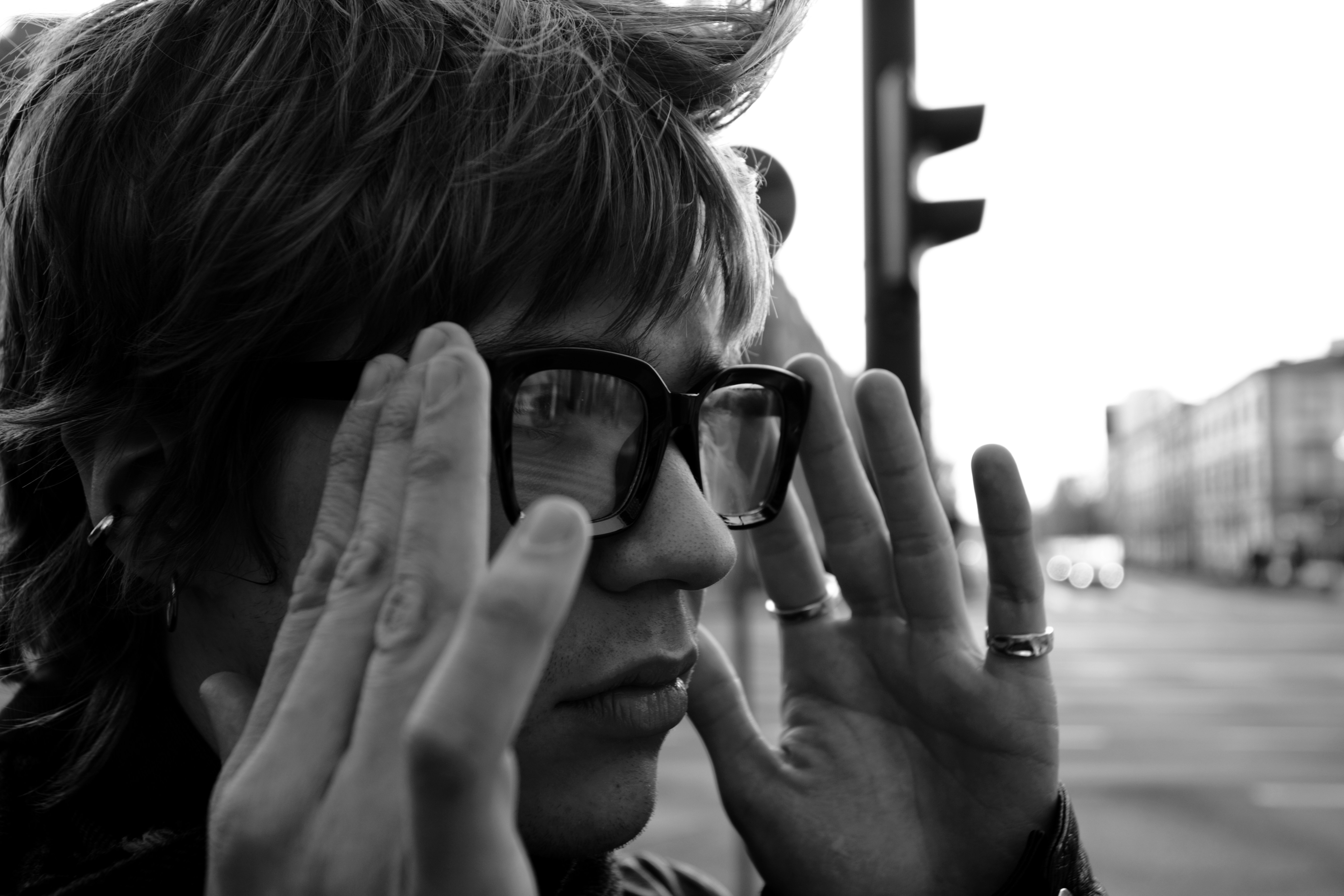 Glasses on Pause: A Moment of Quiet Street Threshold