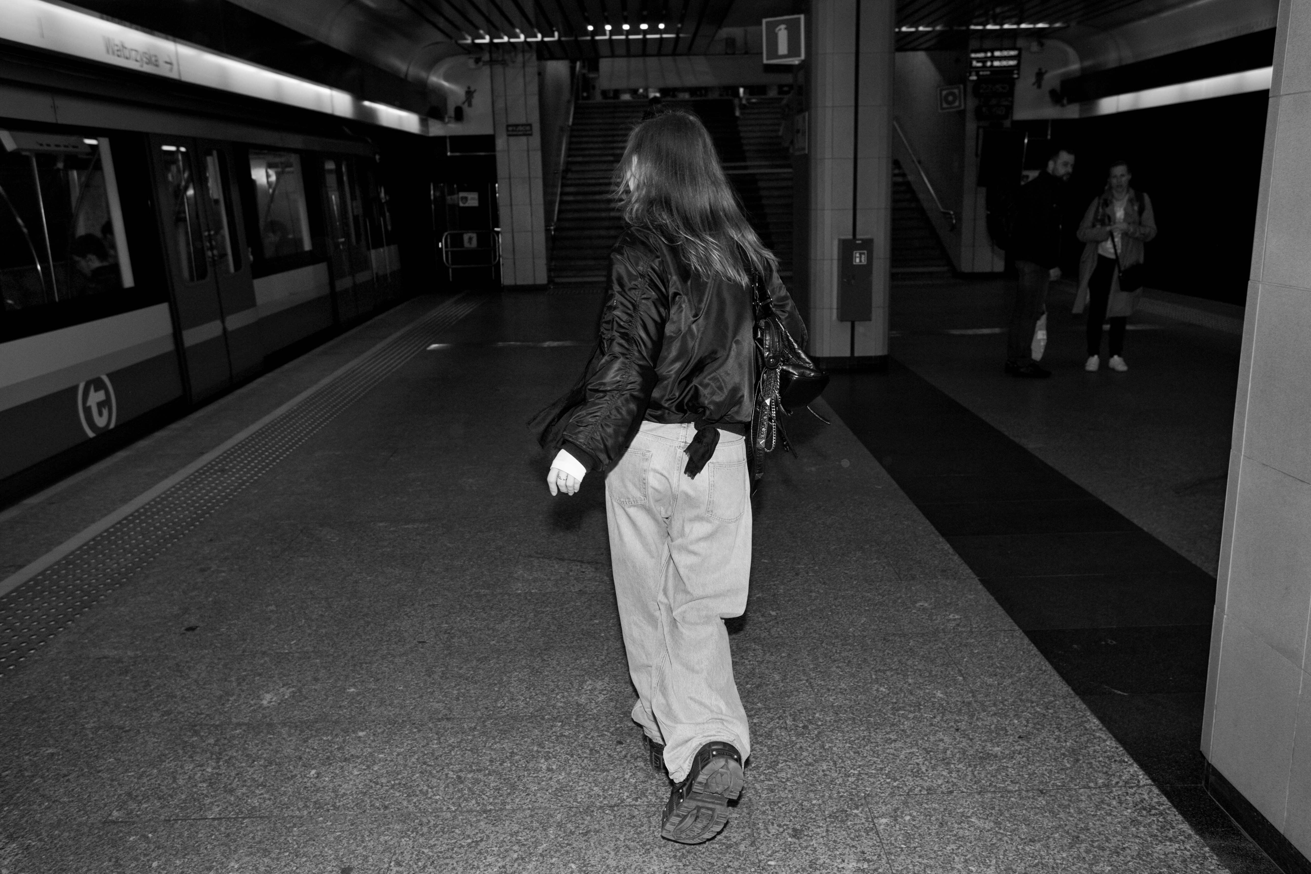 Mid-Platform Turn: A Passenger in Motion at a Suburban Subway