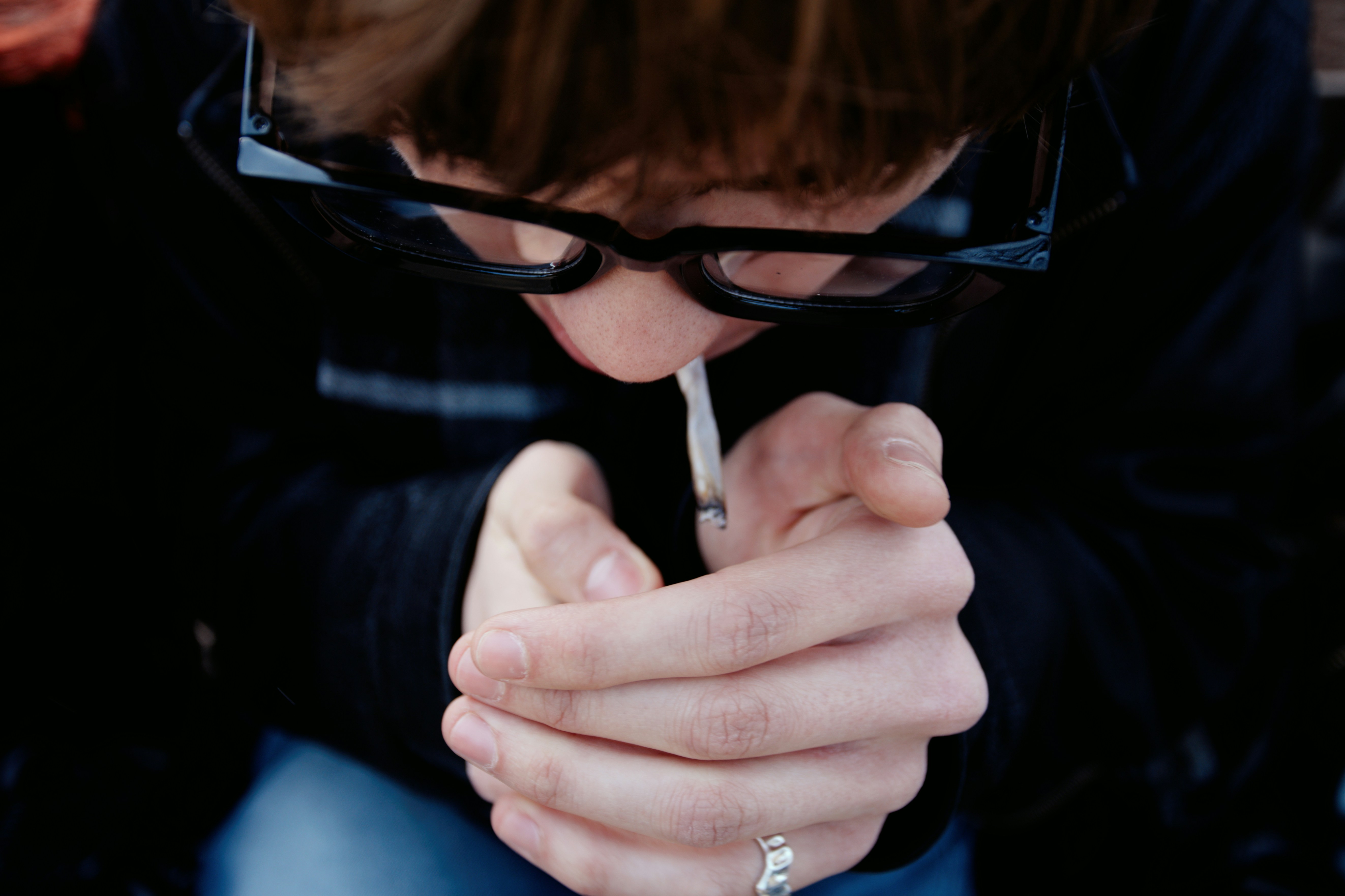 Close-Up of a Hands-On Sourcer: a Glasses-Clad Reader Lighting a Small Object