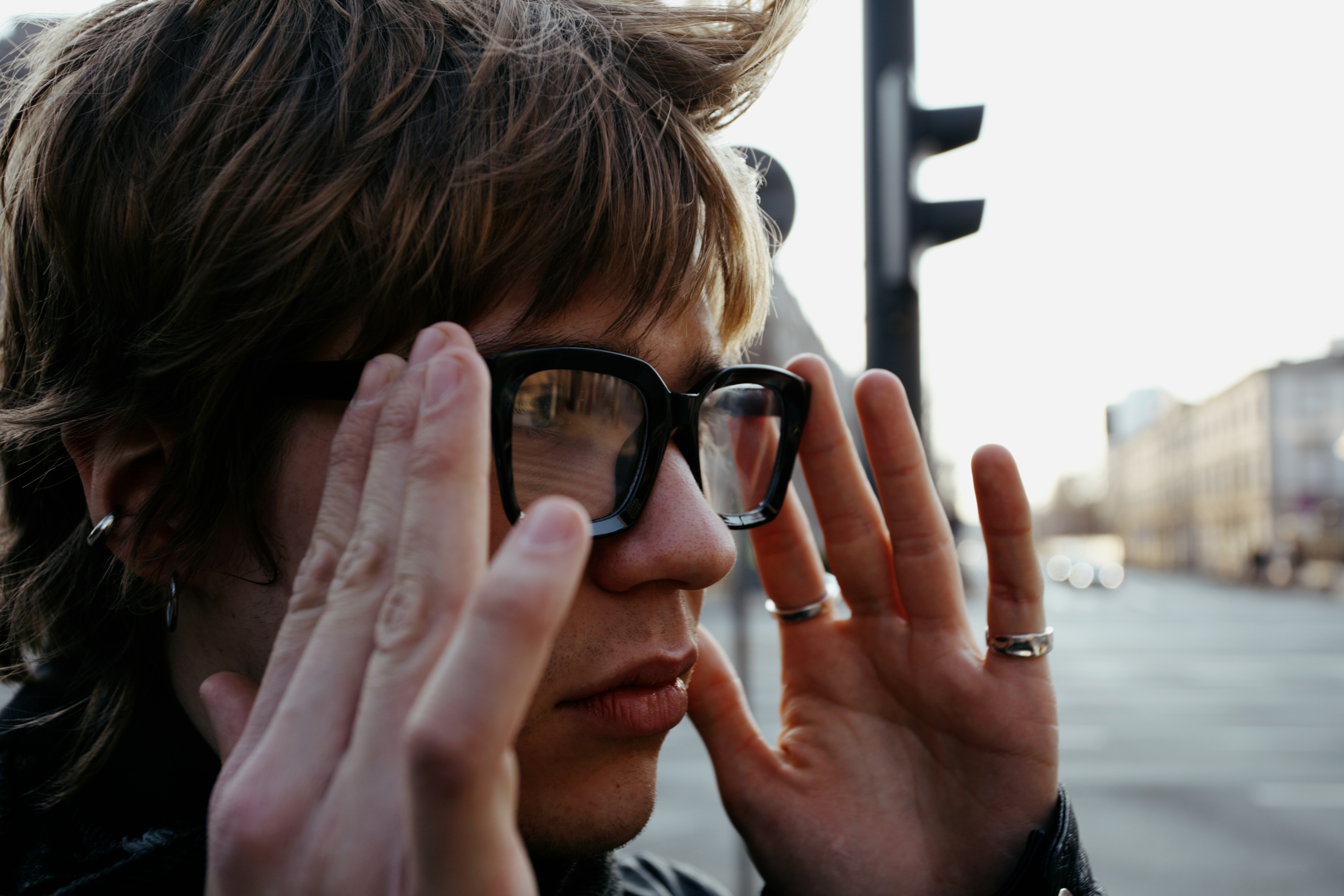 Mid-gesture portrait: adjusting focus and gaze through sunglasses