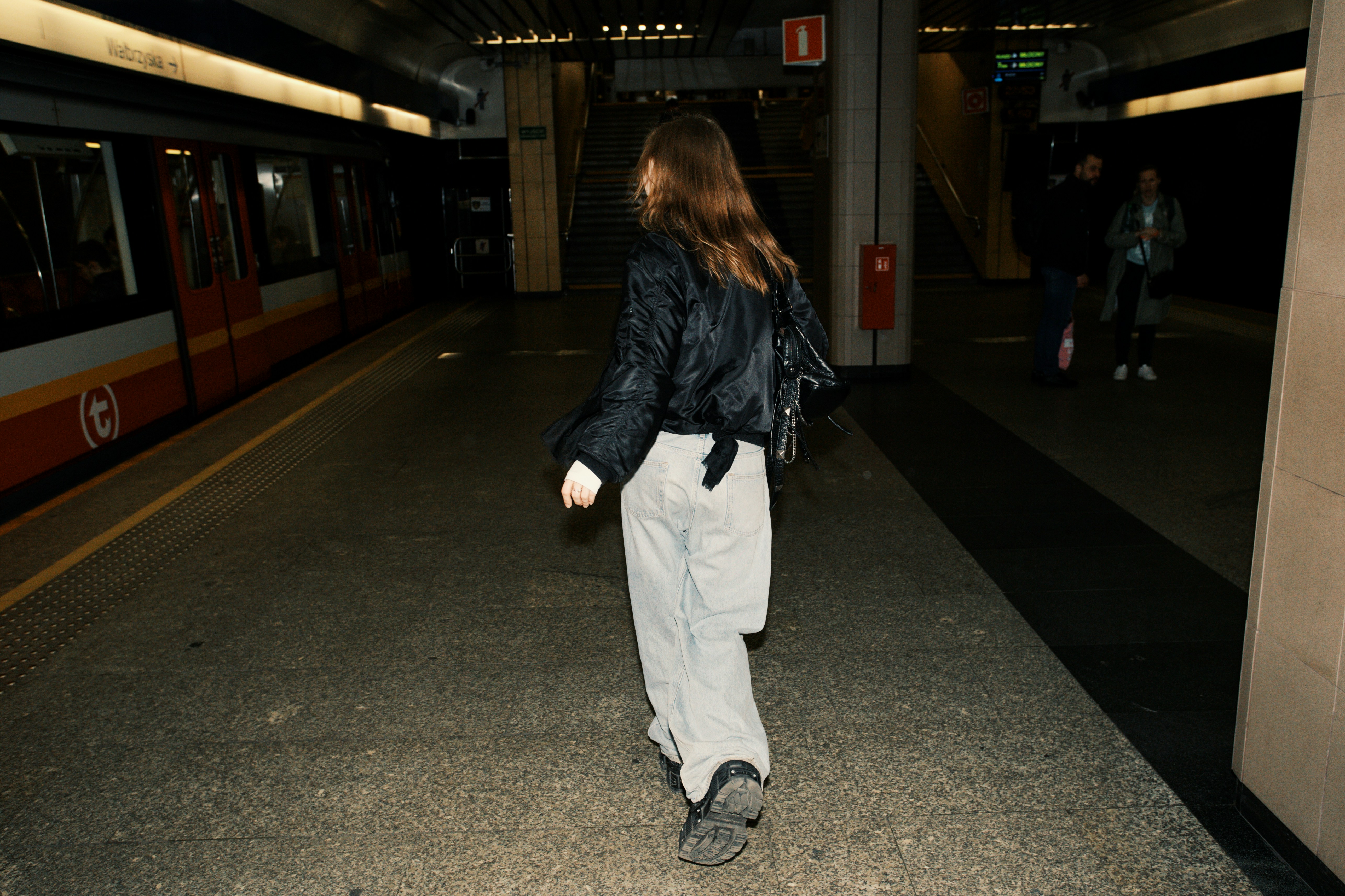 Mid-Step Escape: A Woman Crossing a Quiet Subway Platform