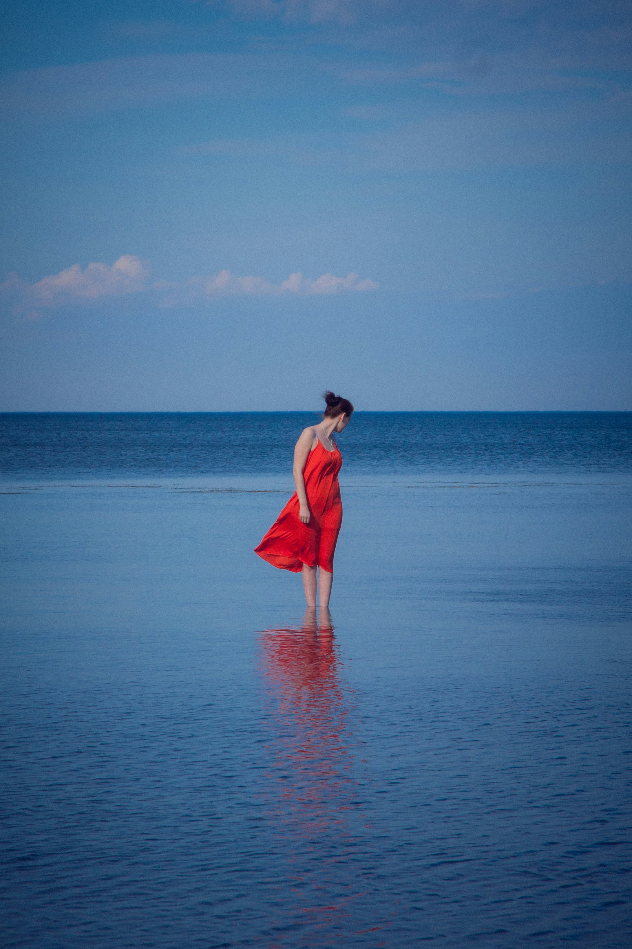 Red Dress at Sea: A Quiet Moment Where Shore Meets Sky