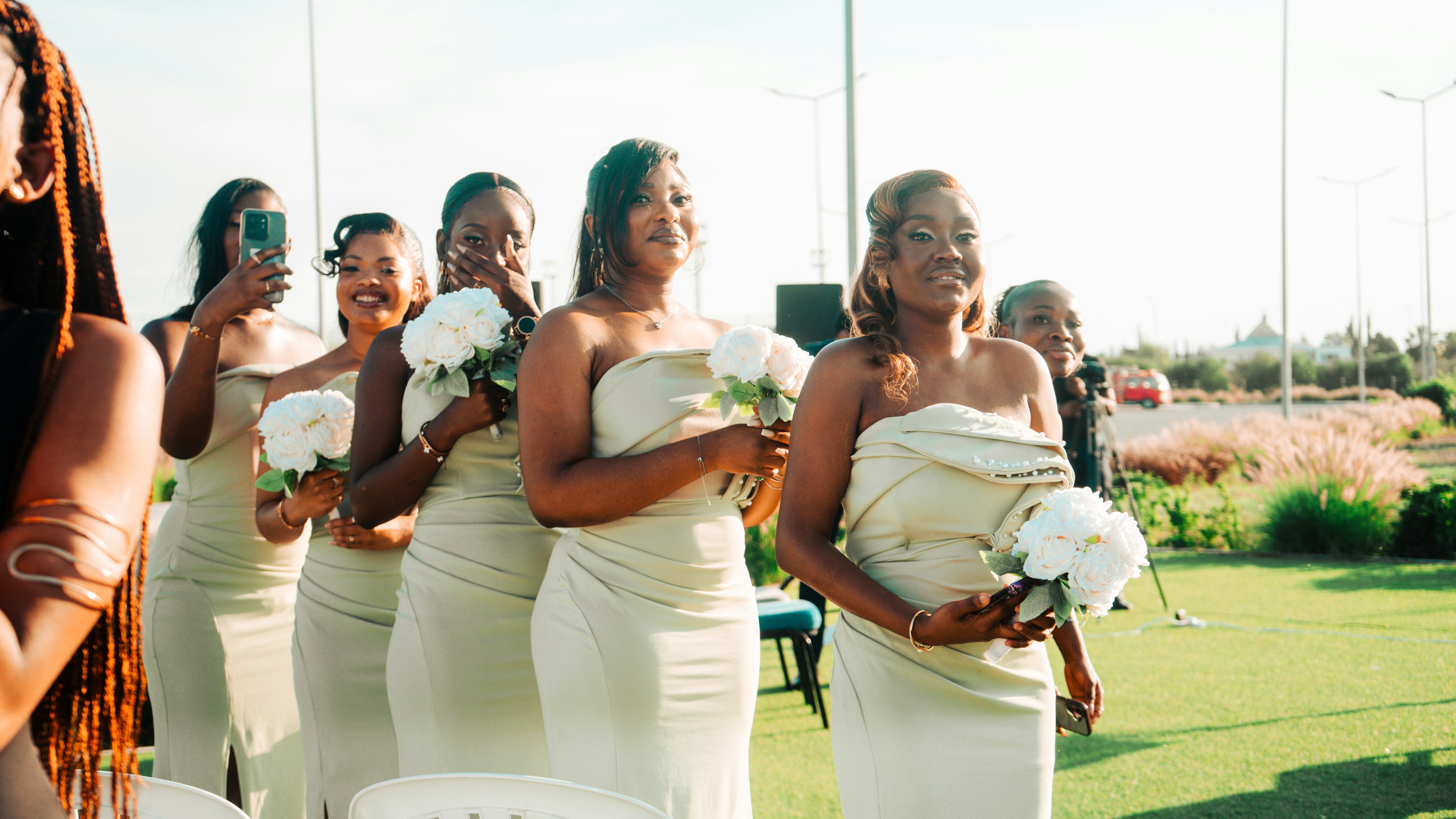 First Honor: A Row of Bridesmaids in Cream Gowns Share a Moment on the Lawn