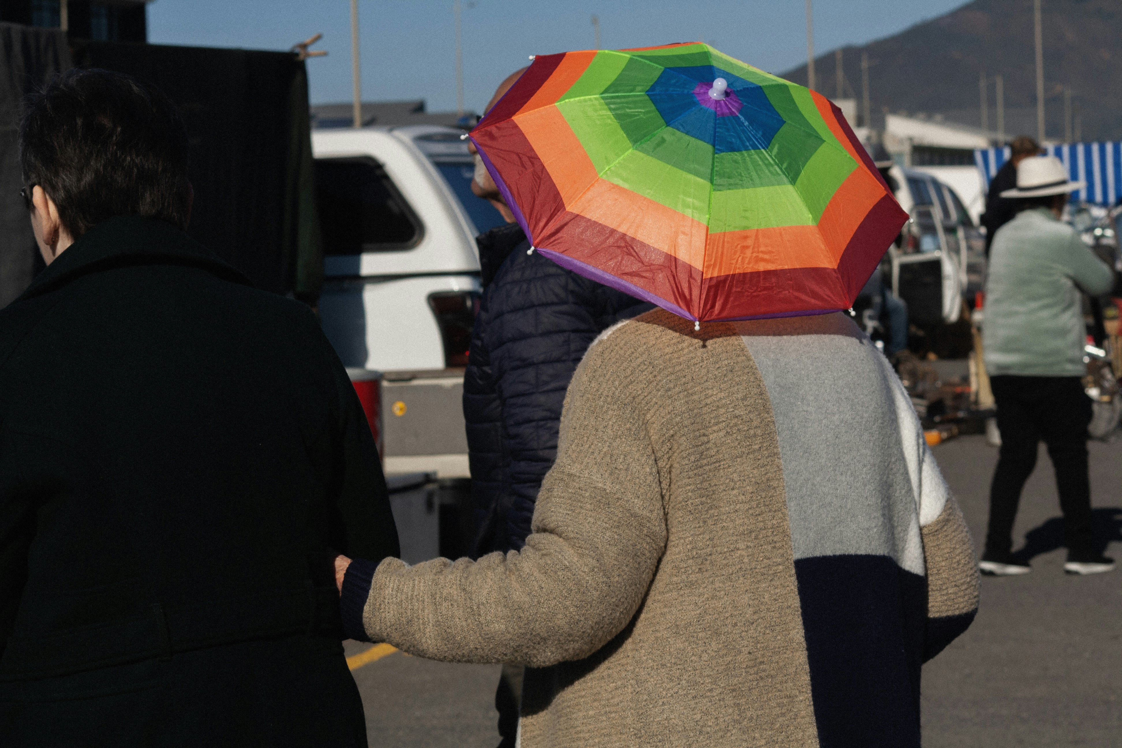 Colorful Umbrella Leads the Walk in a Busy Street Market