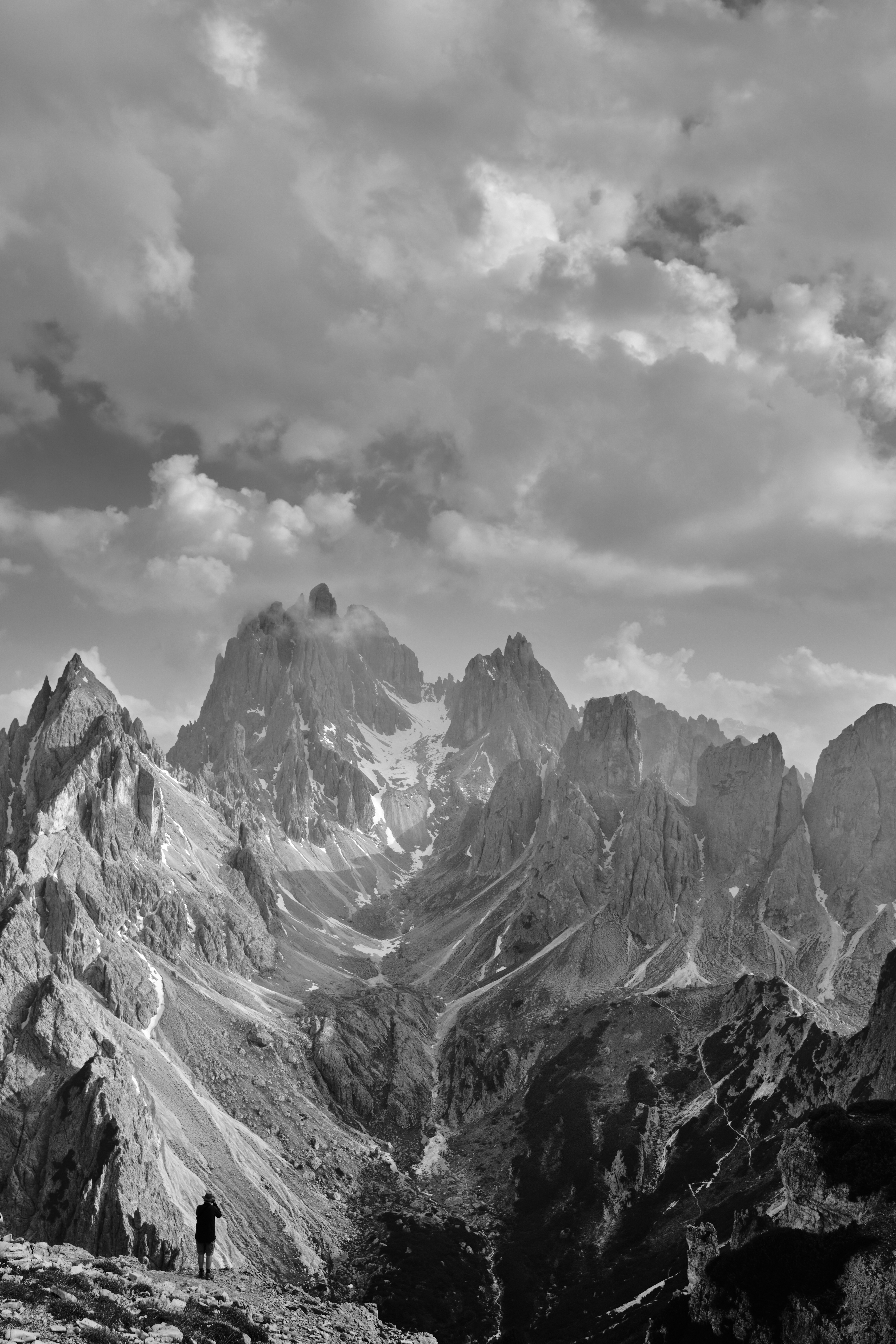Beneath the Jagged Roofs: A Lone Hiker in a Valorous Mountain Basin