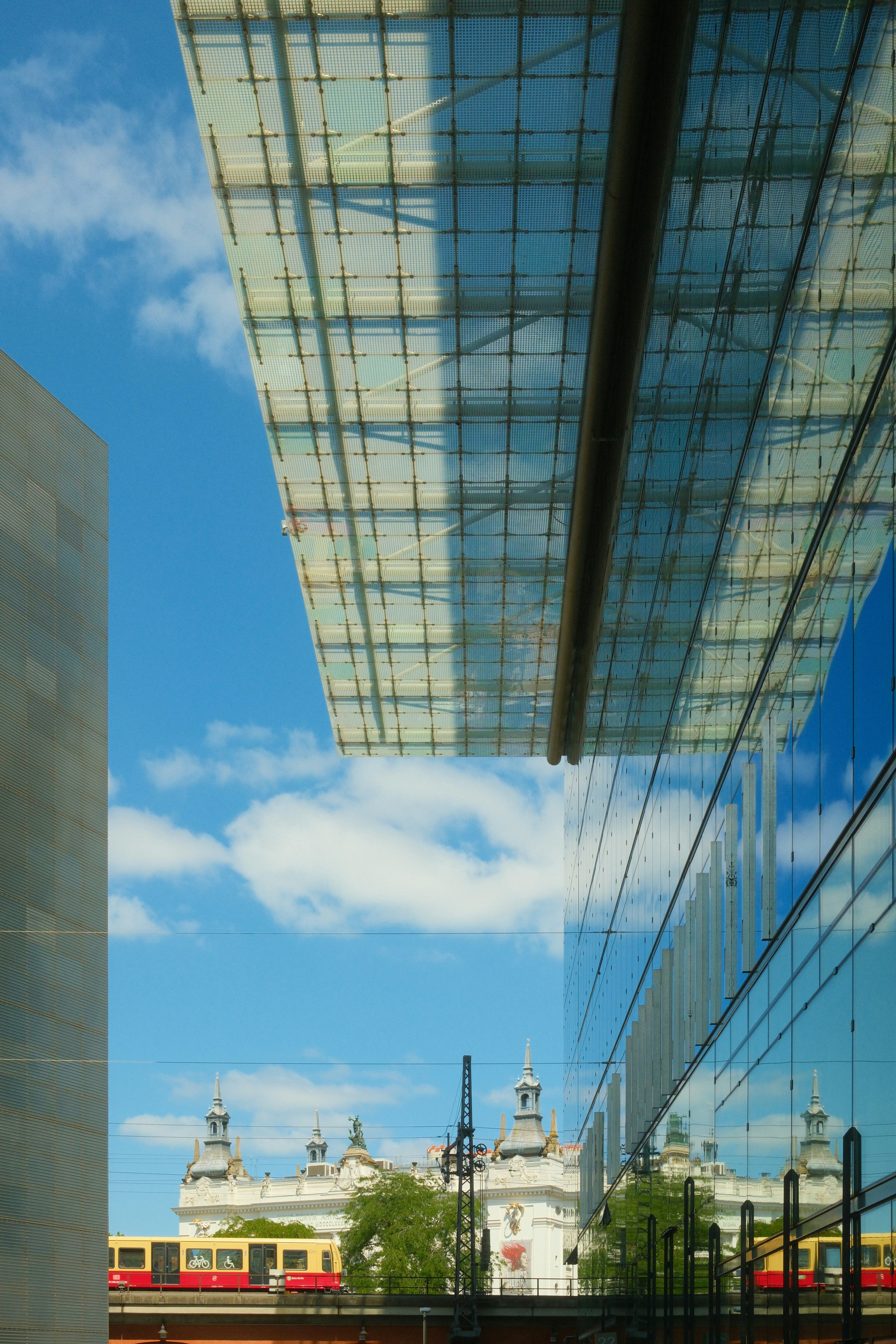 Glass and Sky: Cityscape Framed by Modern Canopy