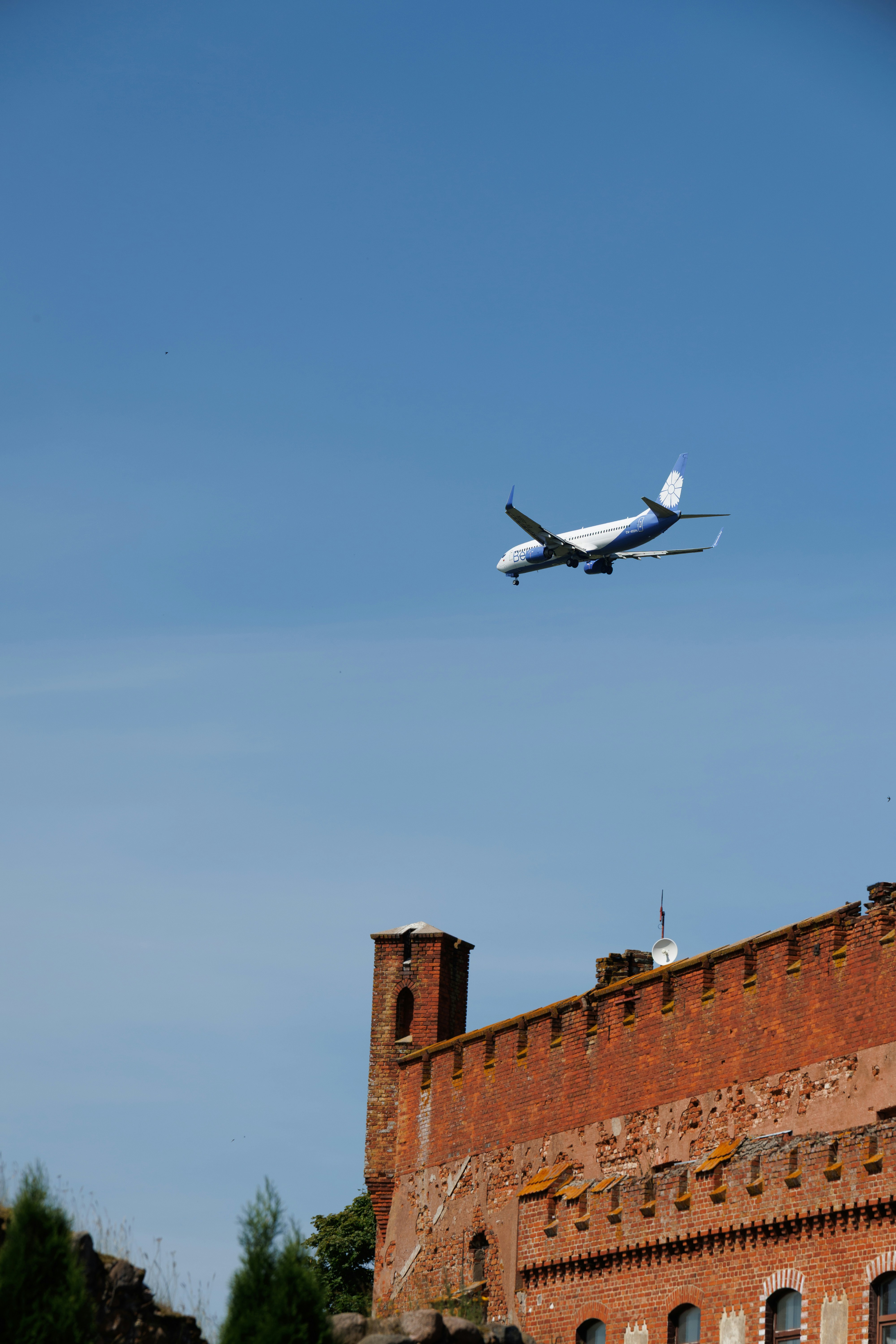 Skyward Landing: A Passenger Jet Trims the Horizon Above a Brick Fort