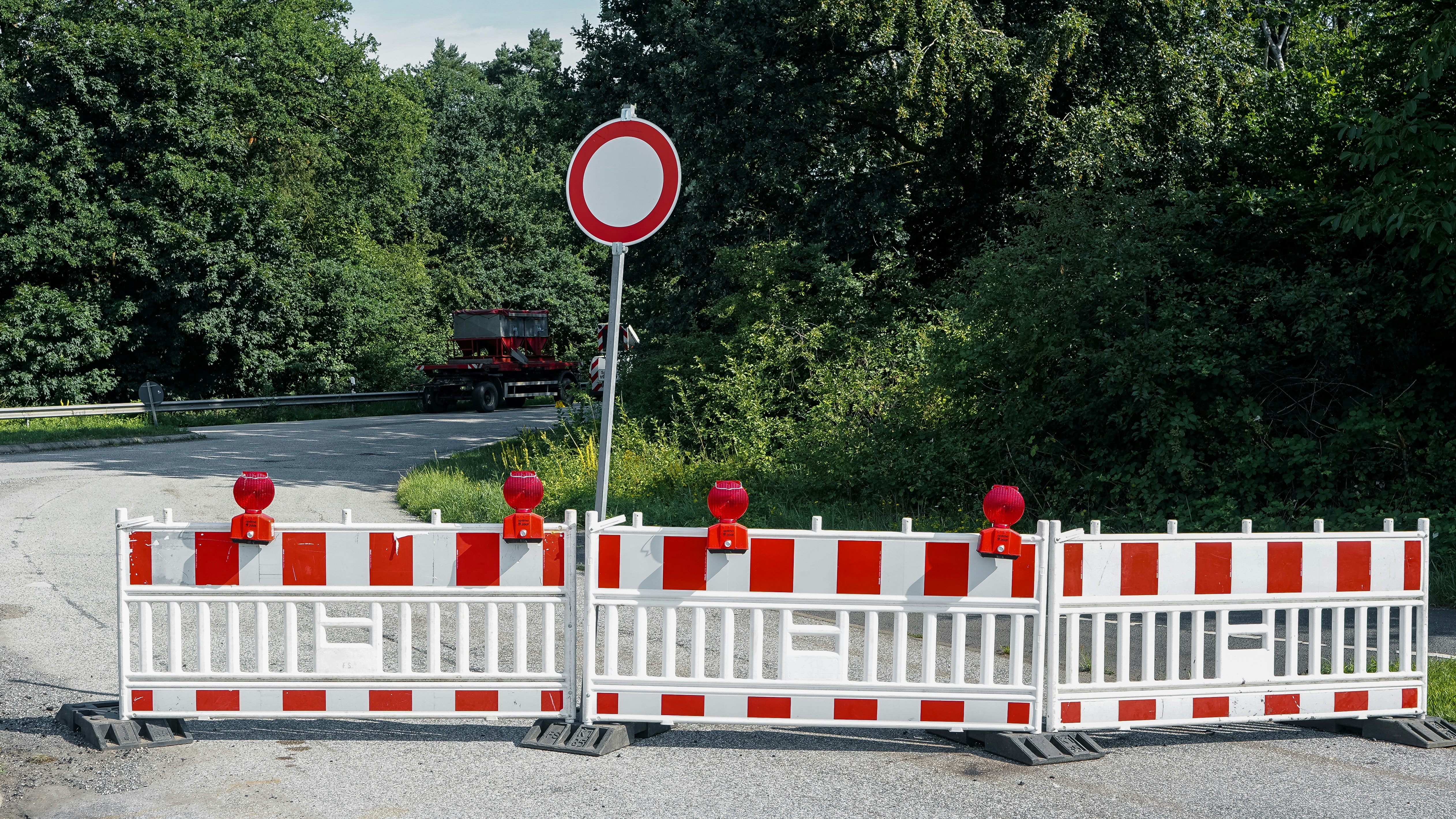 Barricaded Lane: A Quiet Roadblock under a Signpost